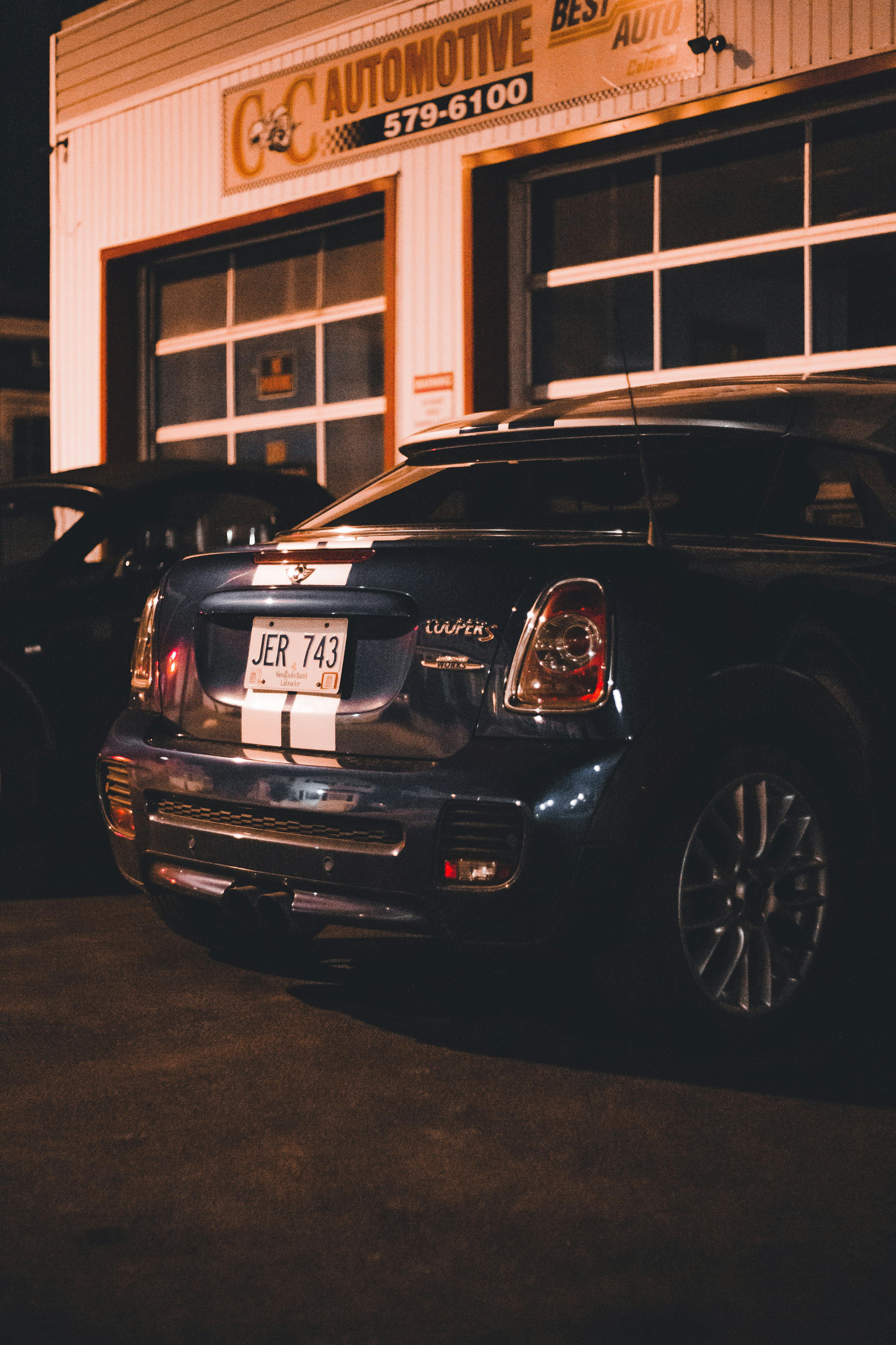 Black Mini Cooper Parked Outside Automotive Shop · Free Stock Photo
