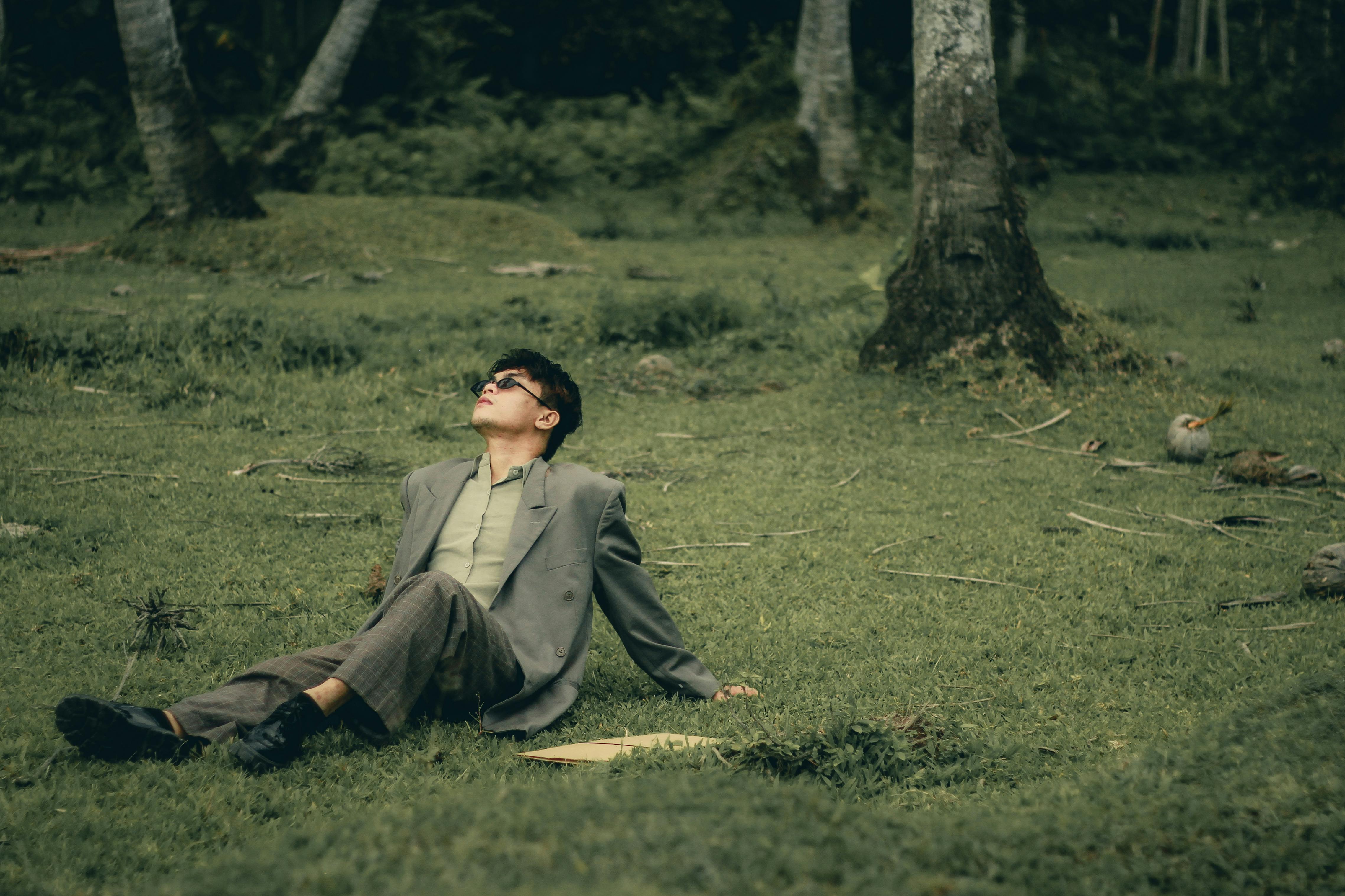 Elegant Man in Sunglasses Sitting on Grass · Free Stock Photo