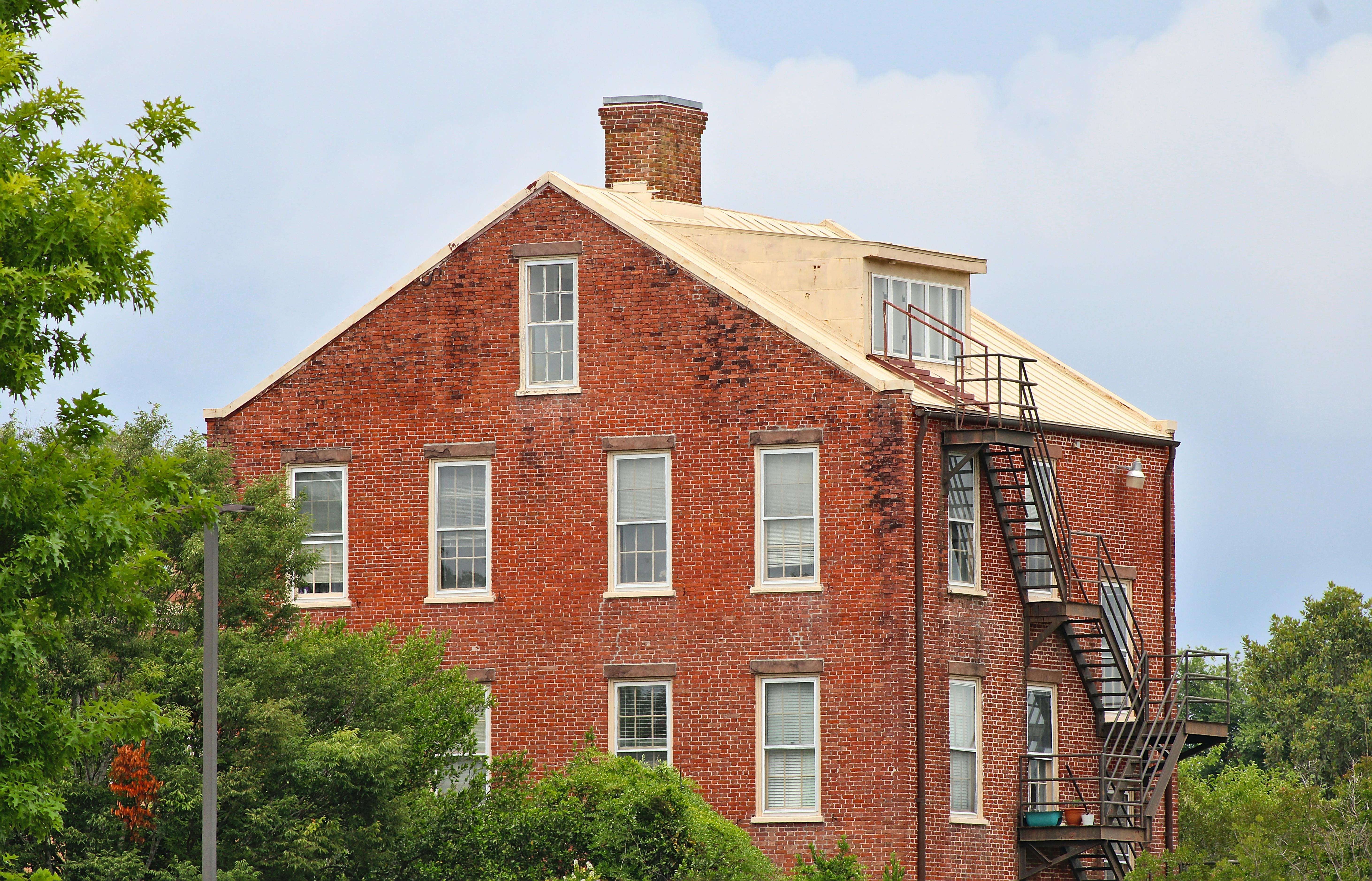 House Made of Bricks Near Green Trees Under Blue Sky · Free Stock Photo