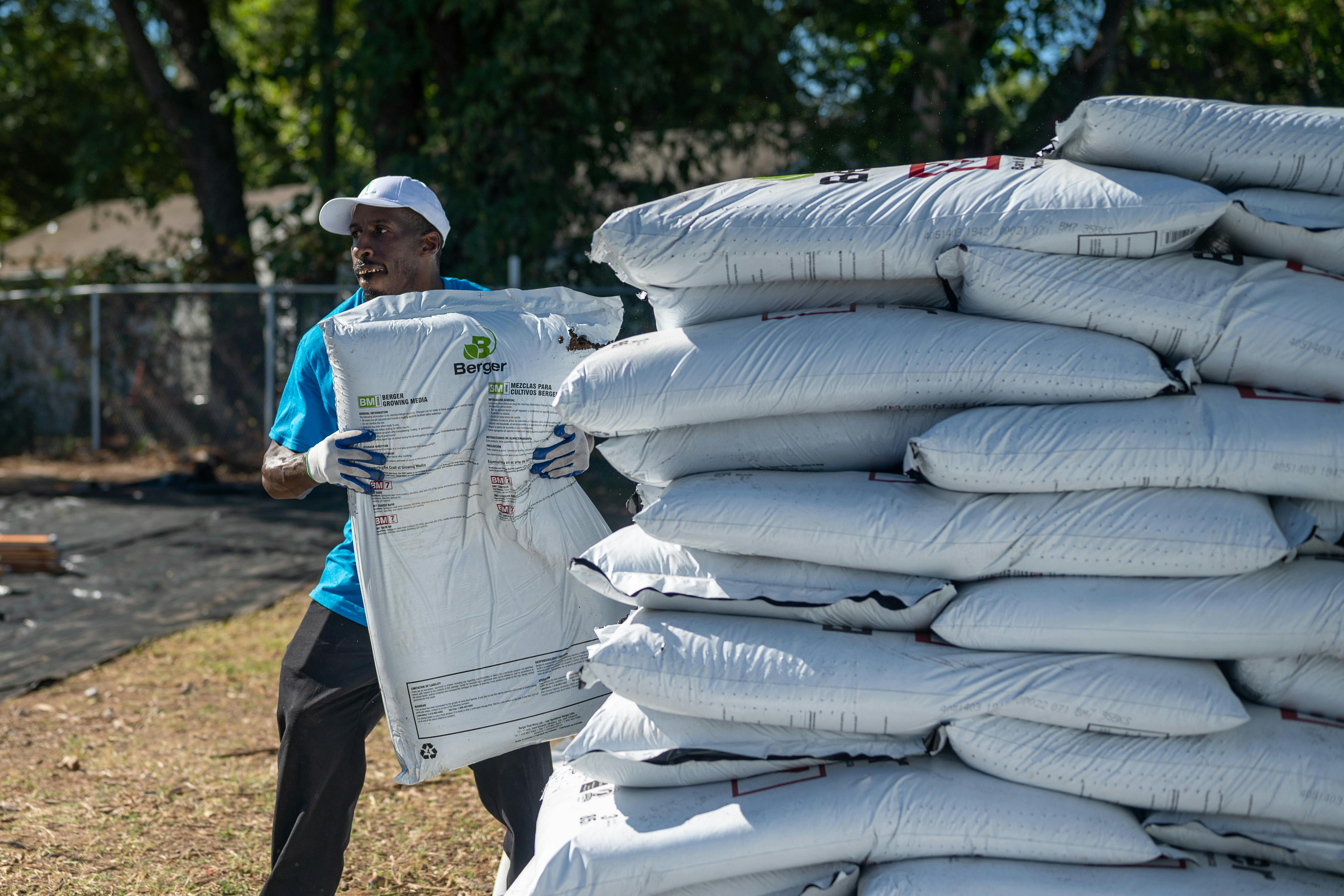 Man Stacking Sacks of Soil · Free Stock Photo