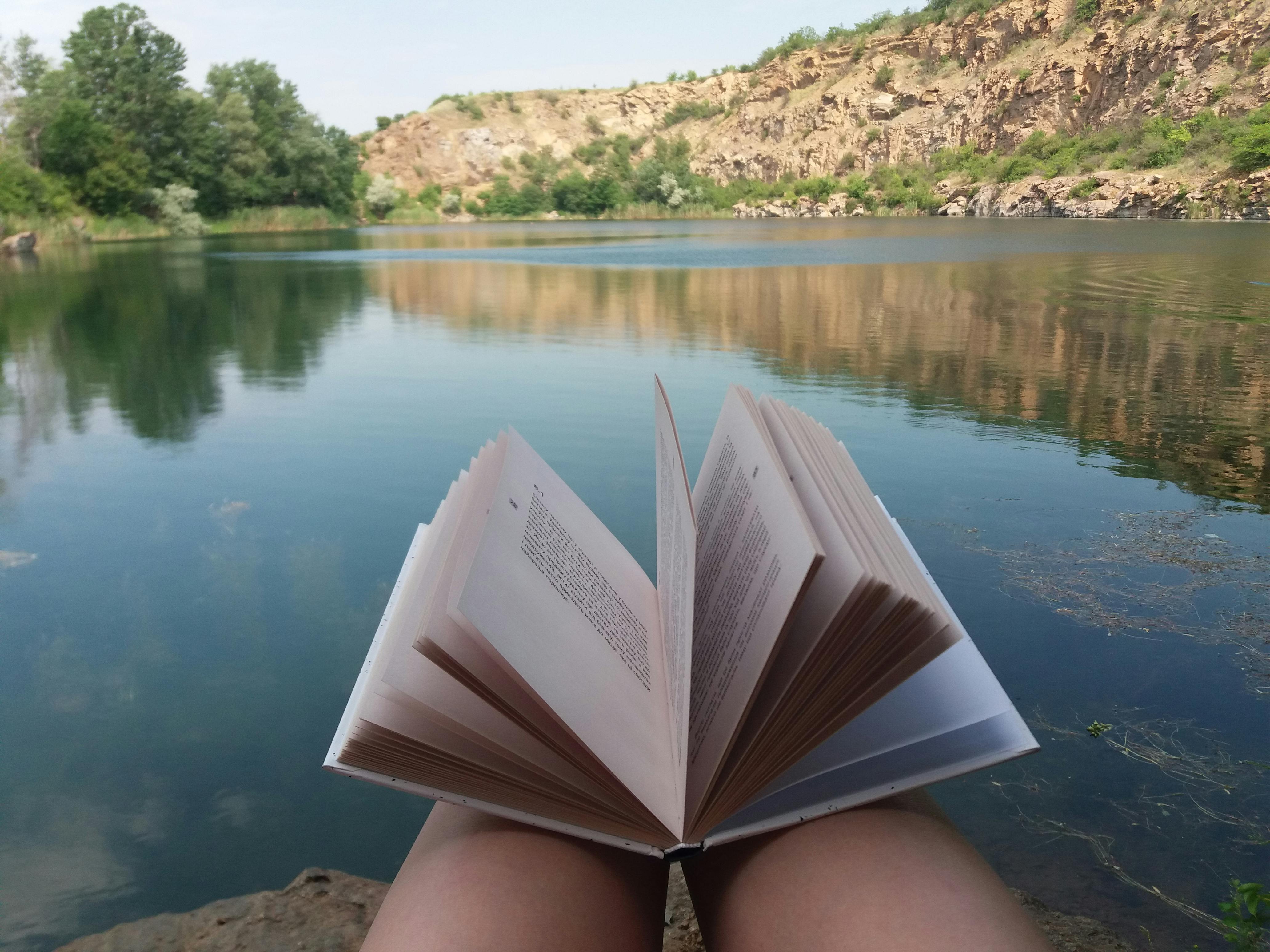 A Person Reading a Book by the Water · Free Stock Photo