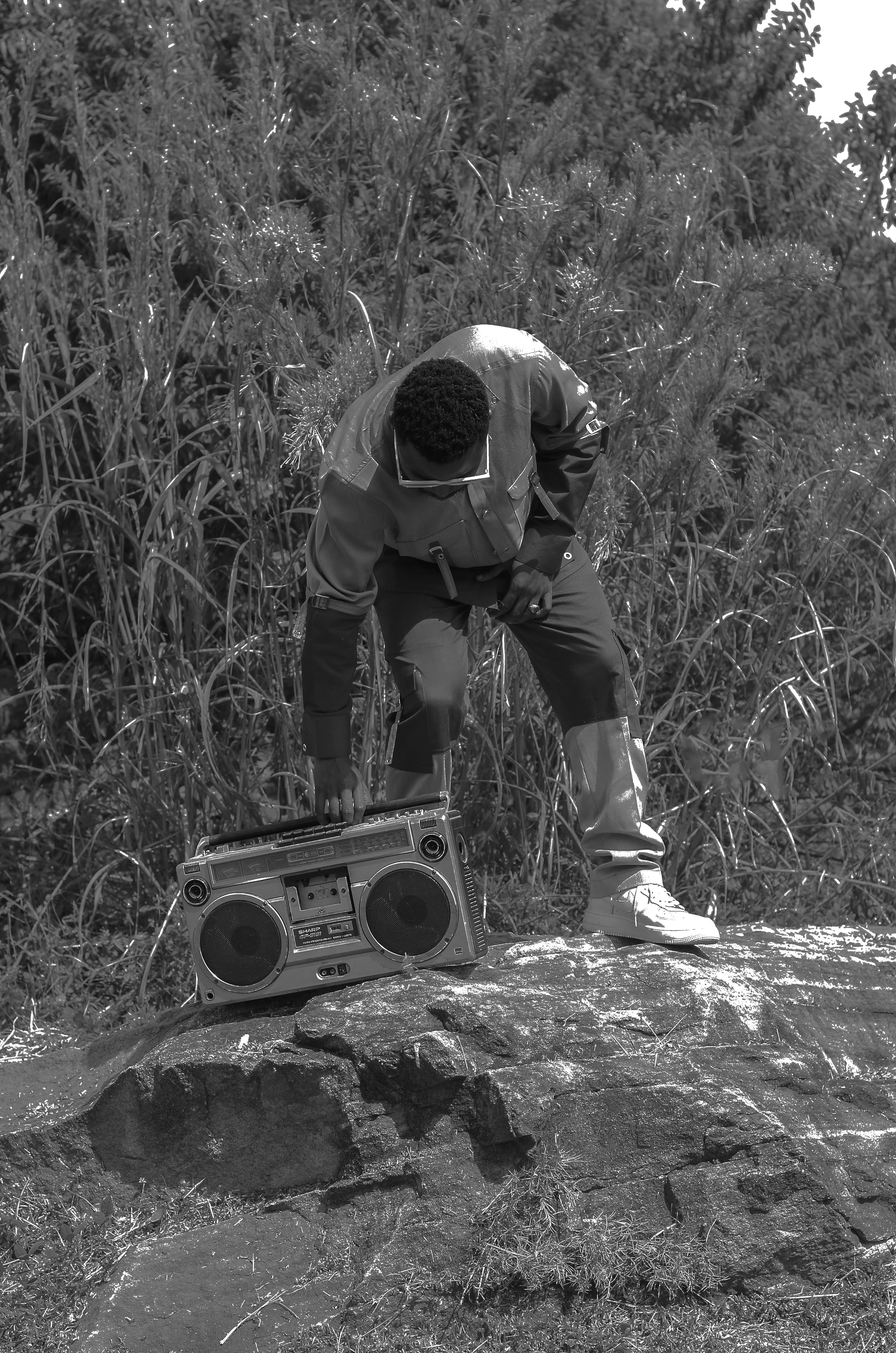 Man Standing Near a Cassette Radio on a Rock · Free Stock Photo