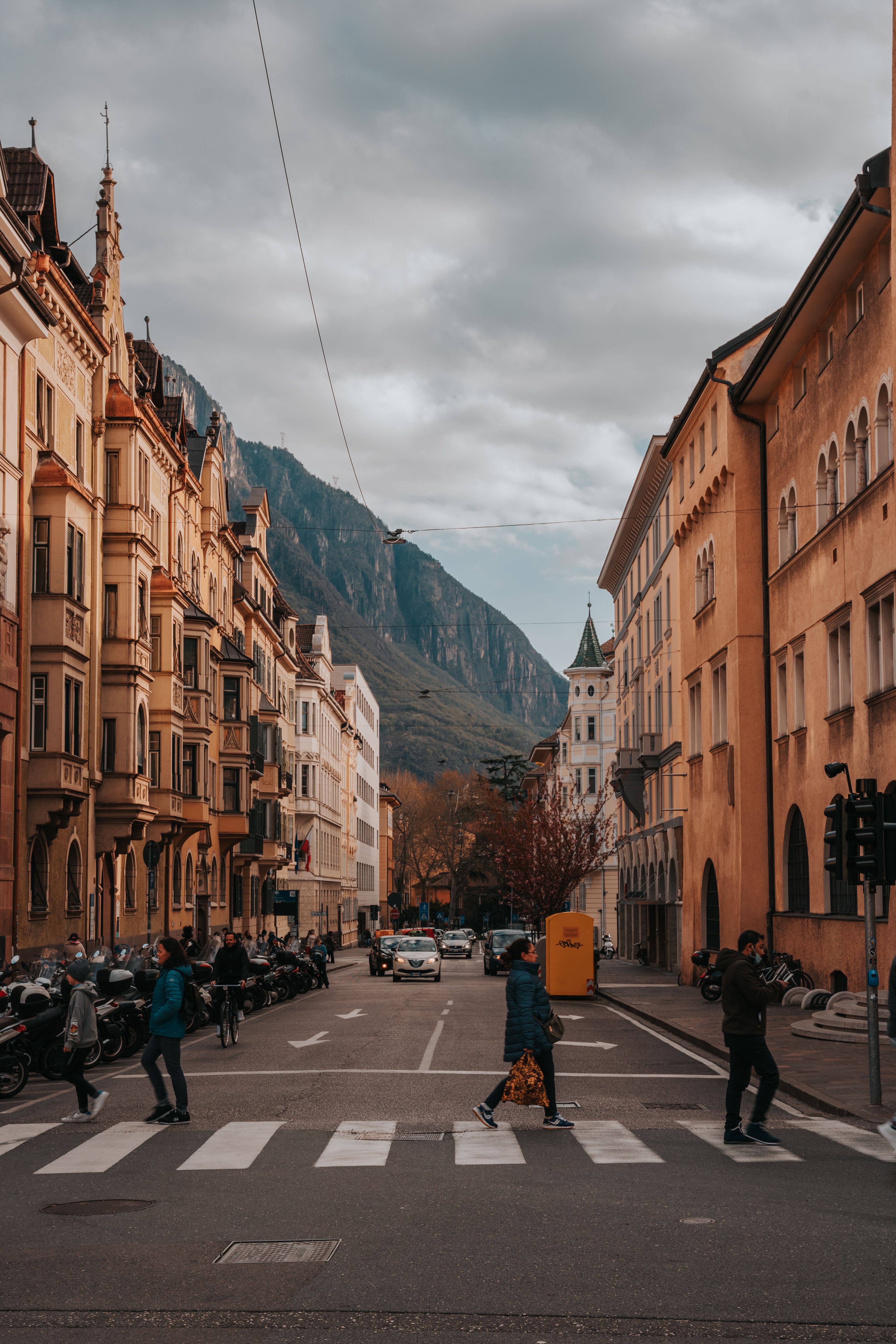 People Crossing the Street Between City Buildings · Free Stock Photo
