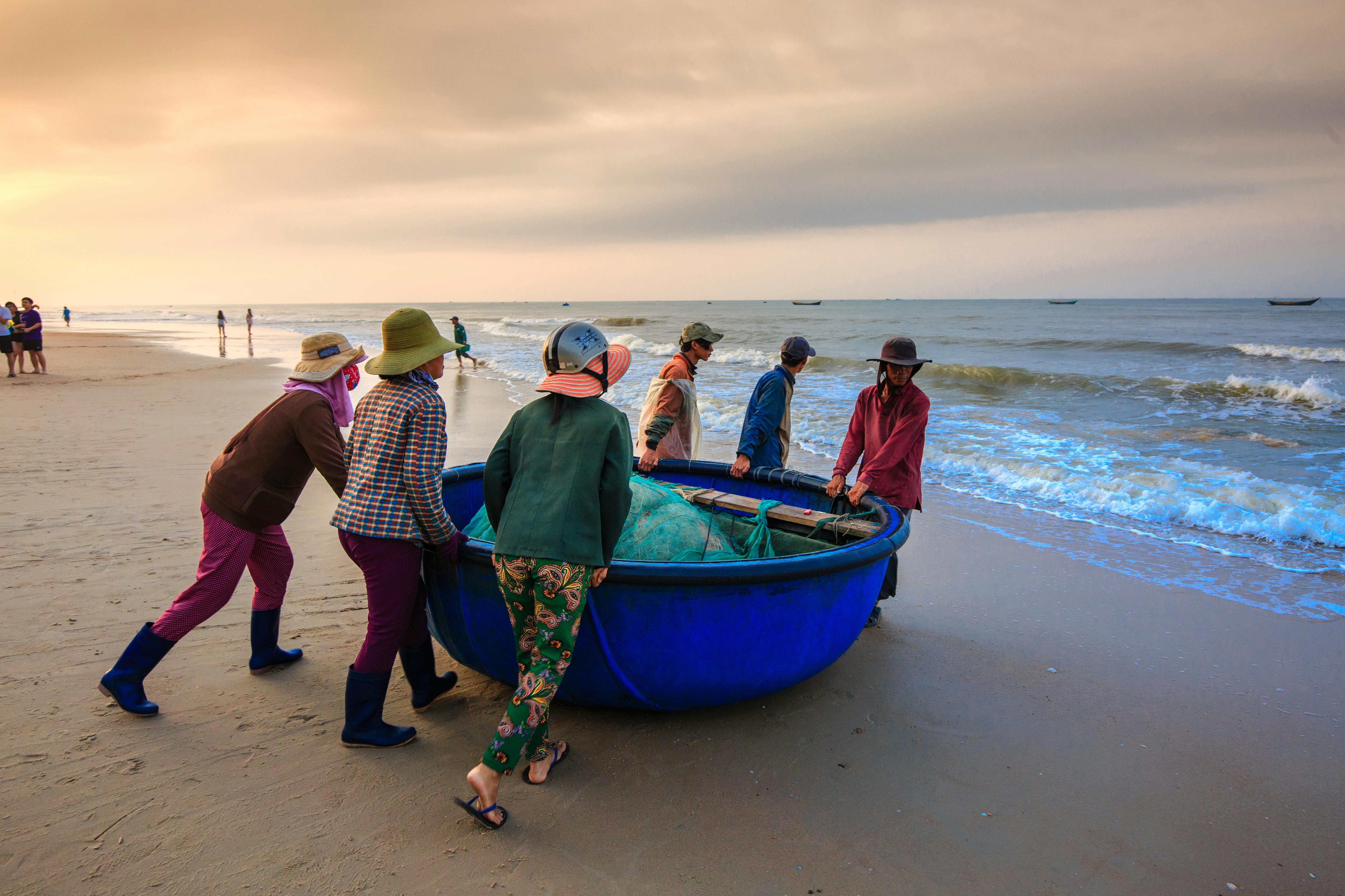 People Carrying a Boat into the Sea · Free Stock Photo
