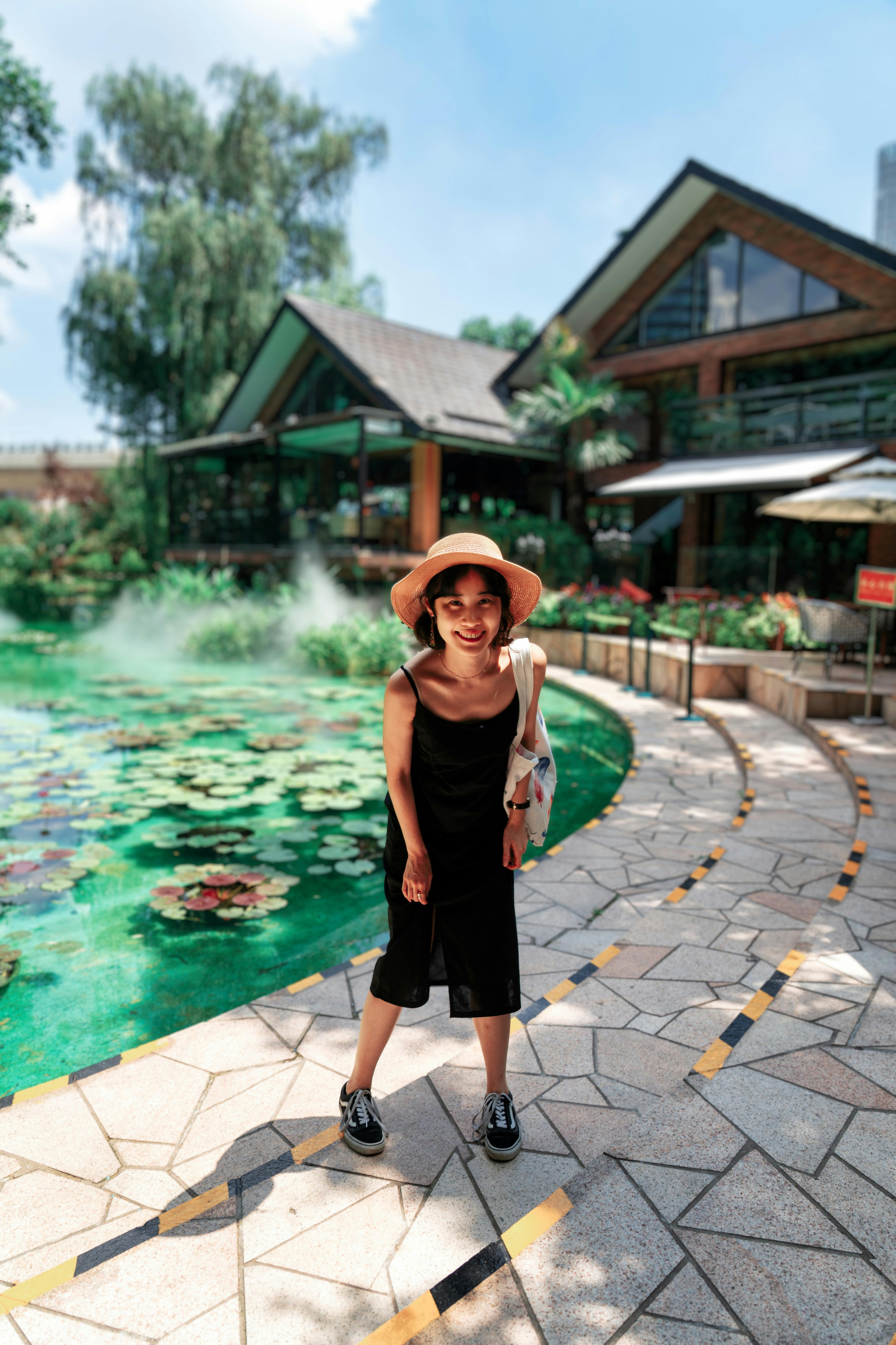 Photo of a Walking Woman in Straw Hat at the Swimming Pool · Free Stock Photo