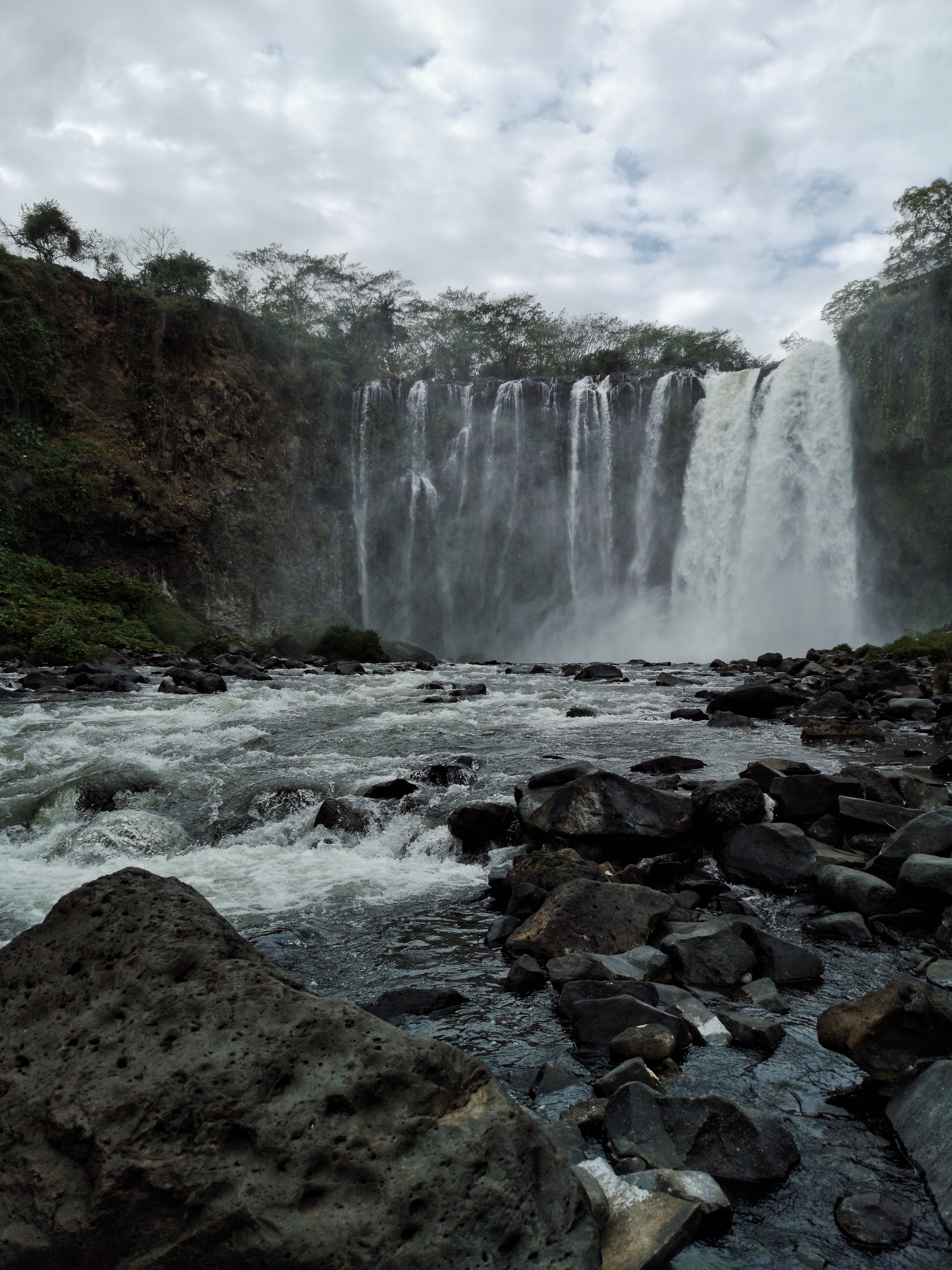 A waterfall is seen in the middle of a river · Free Stock Photo