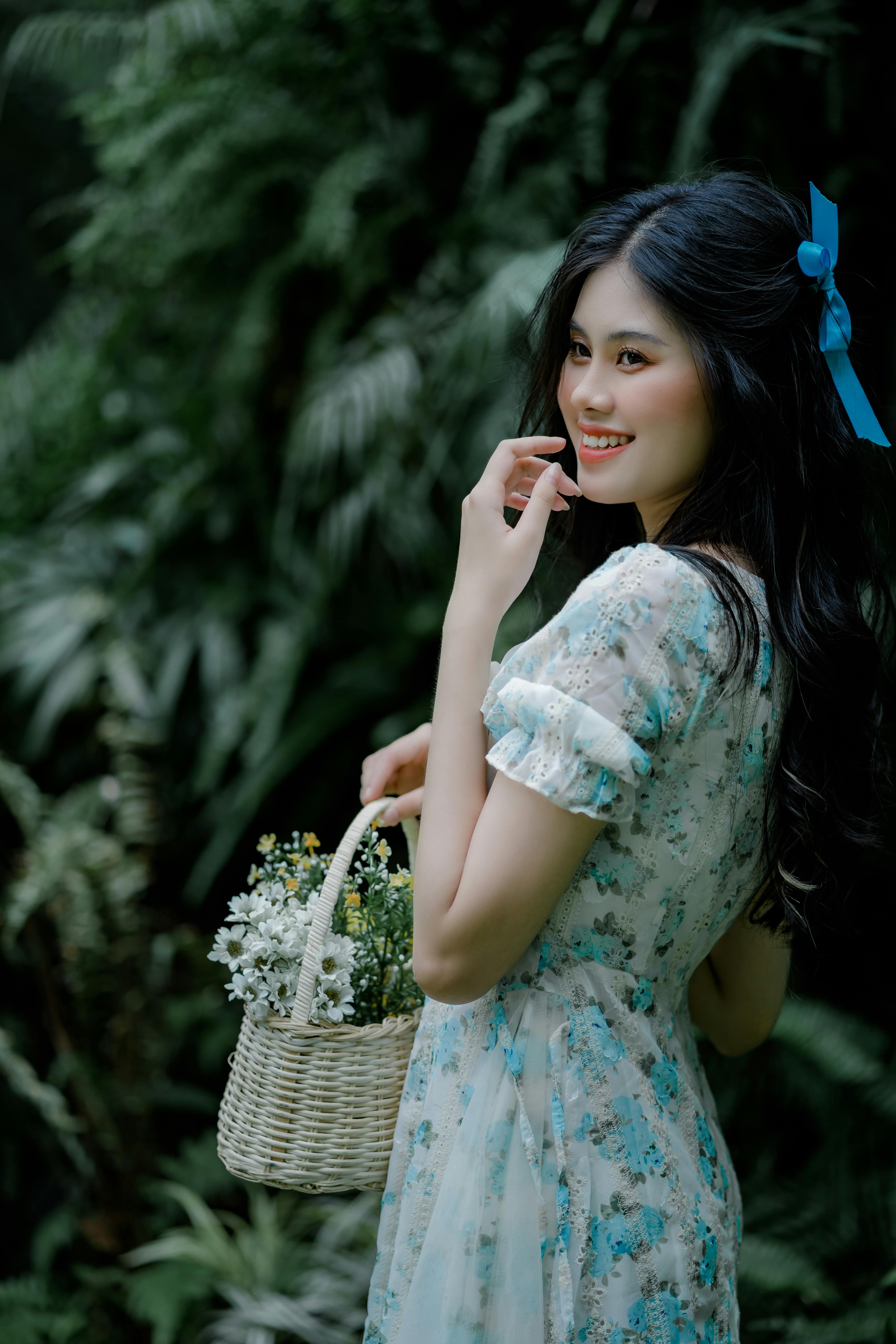 A Woman in White Dress Carrying a Woven Basket in a Flower Field · Free Stock Photo