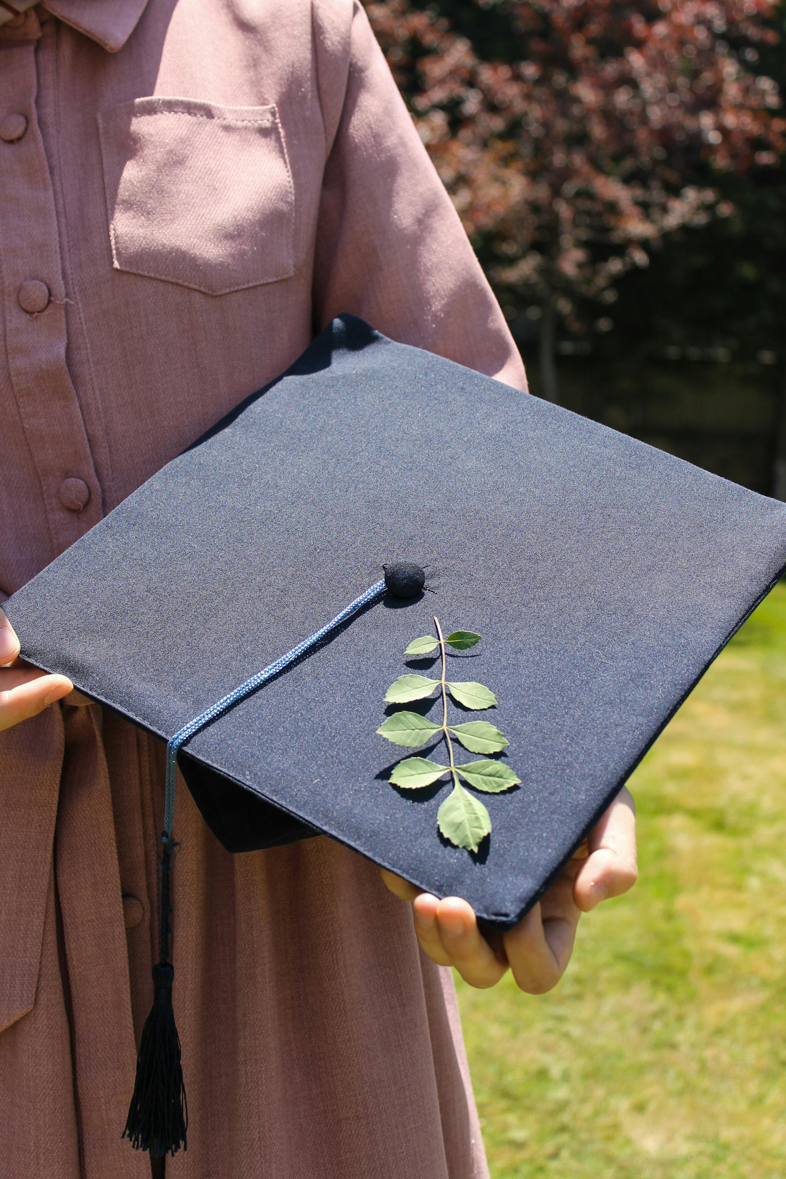 A Person Holding a Black Graduation Hat · Free Stock Photo