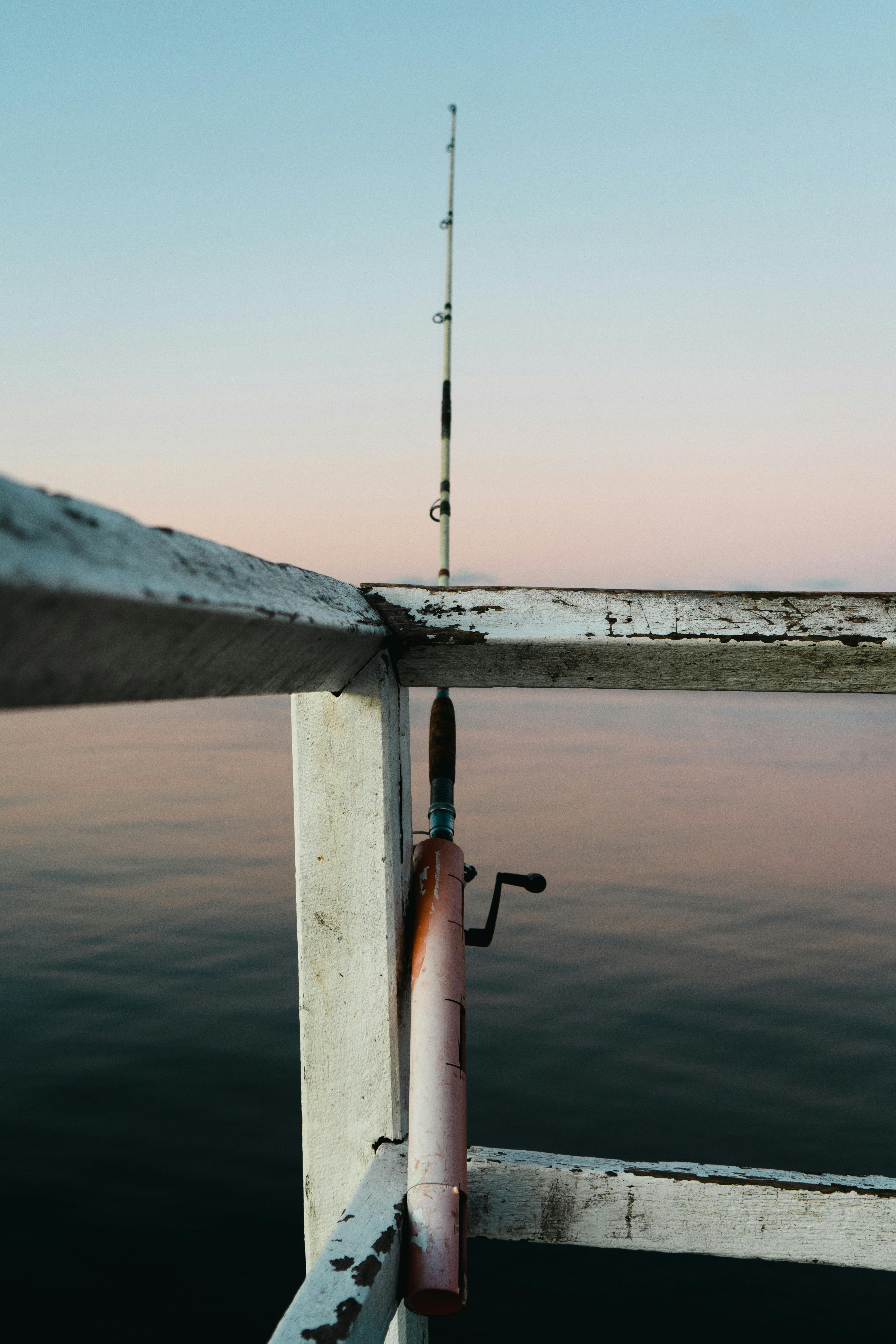 Fishing Rod Leaning on Handrail · Free Stock Photo