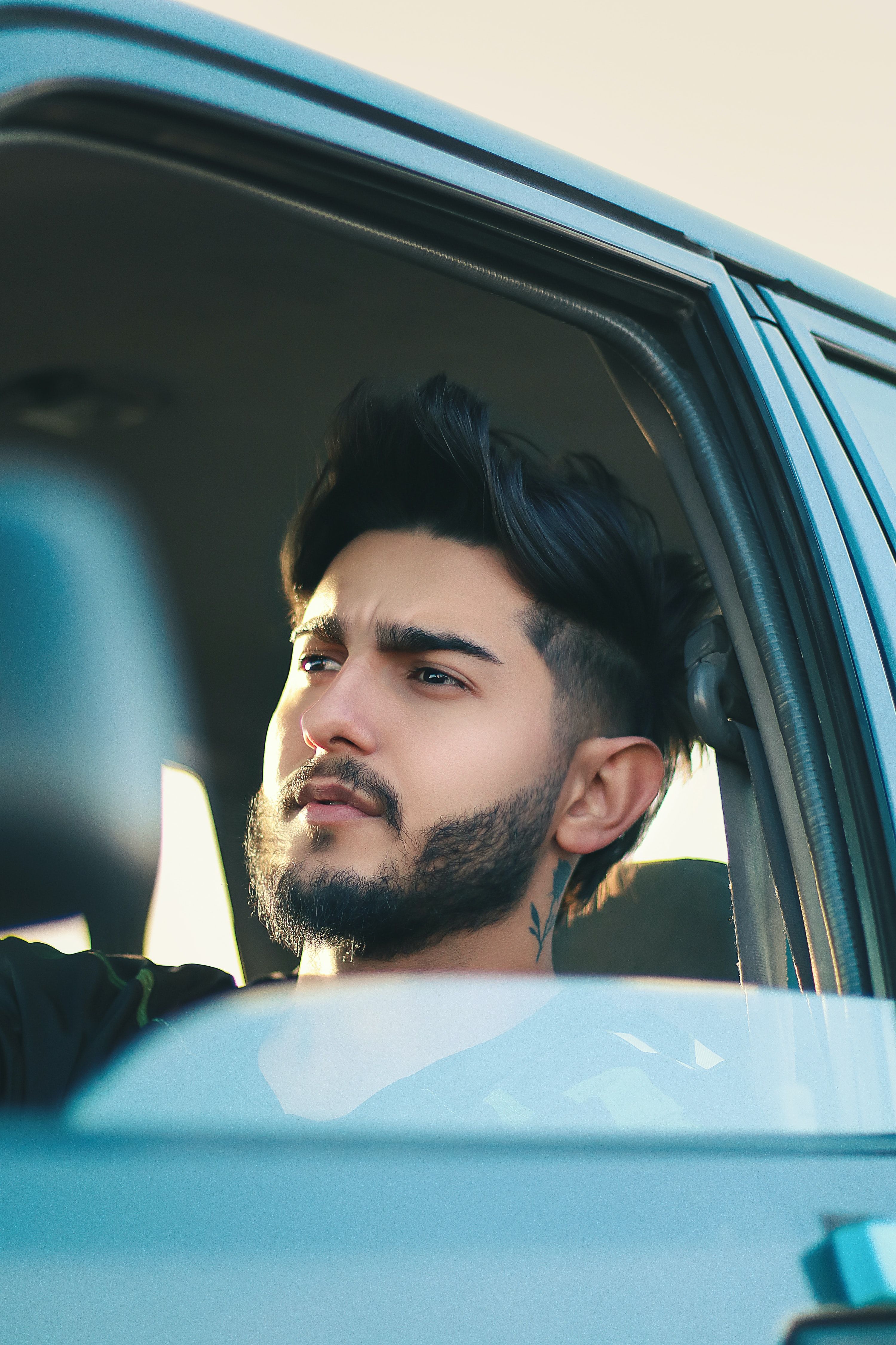 Man with Mustache Sitting on Car Hood · Free Stock Photo