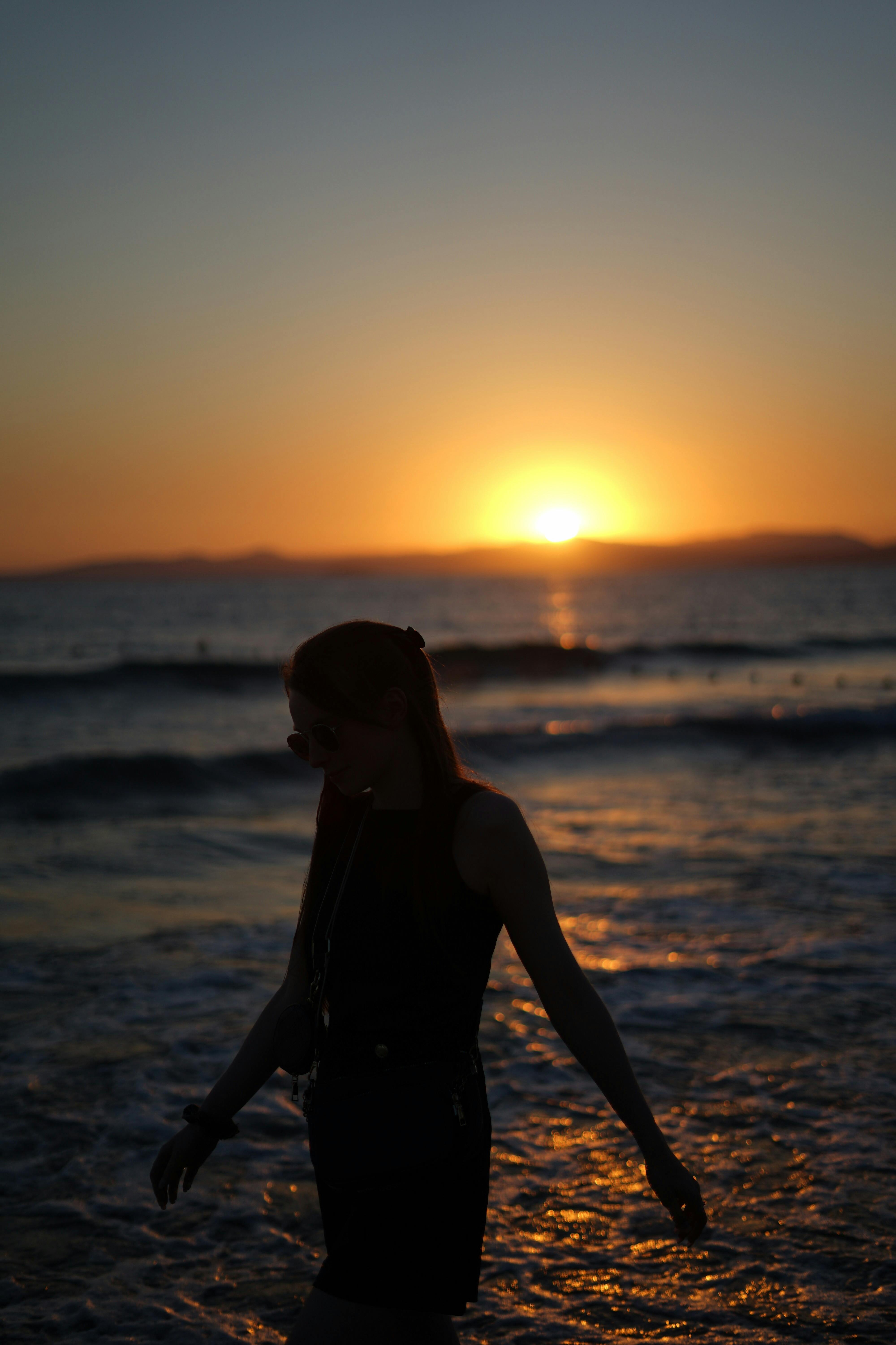 Woman Walking Near Body Of Water · Free Stock Photo