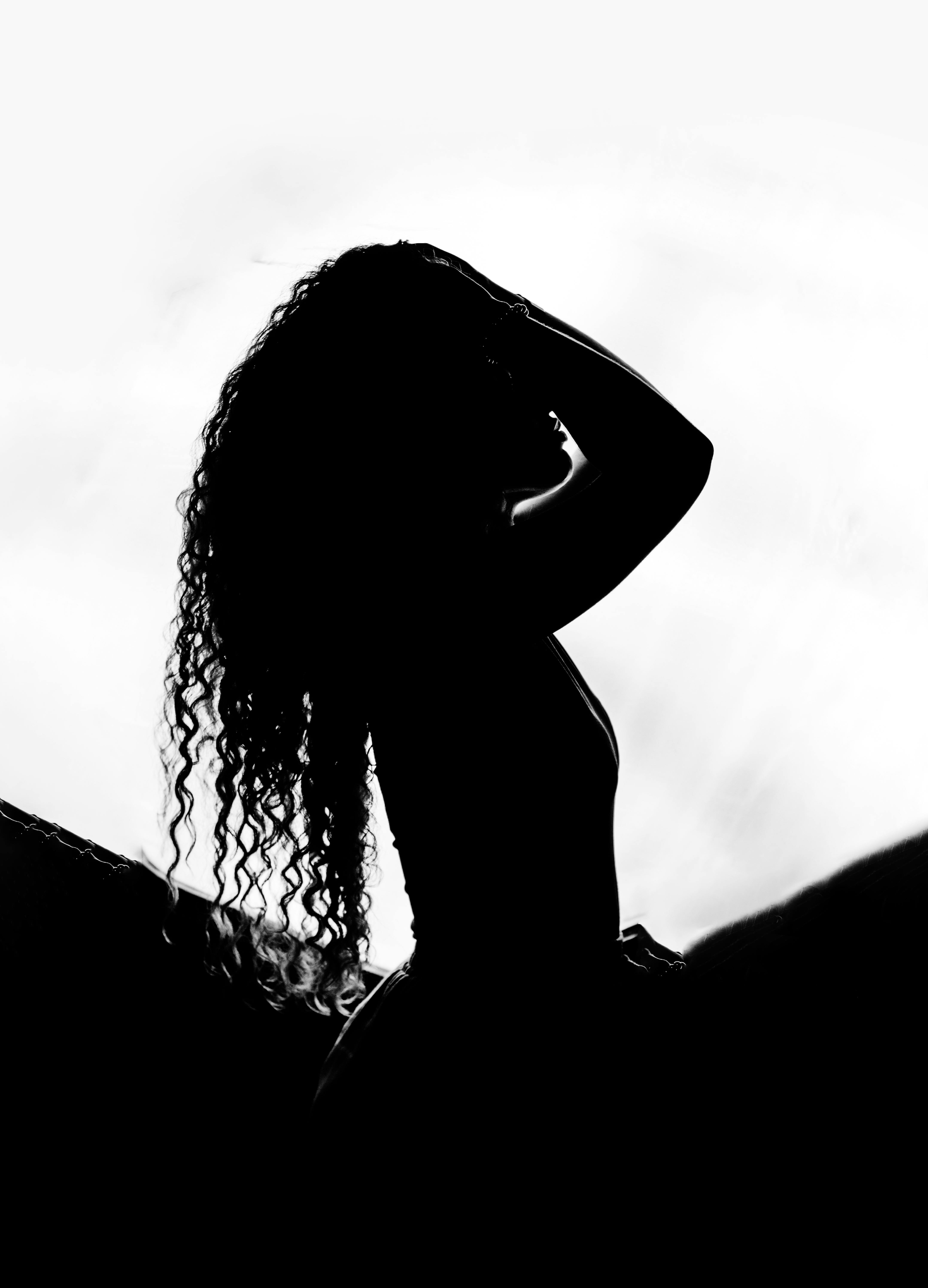 Woman With Red Hair Wearing Black Sexy Outfit Standing Near White Wall While Posing At The