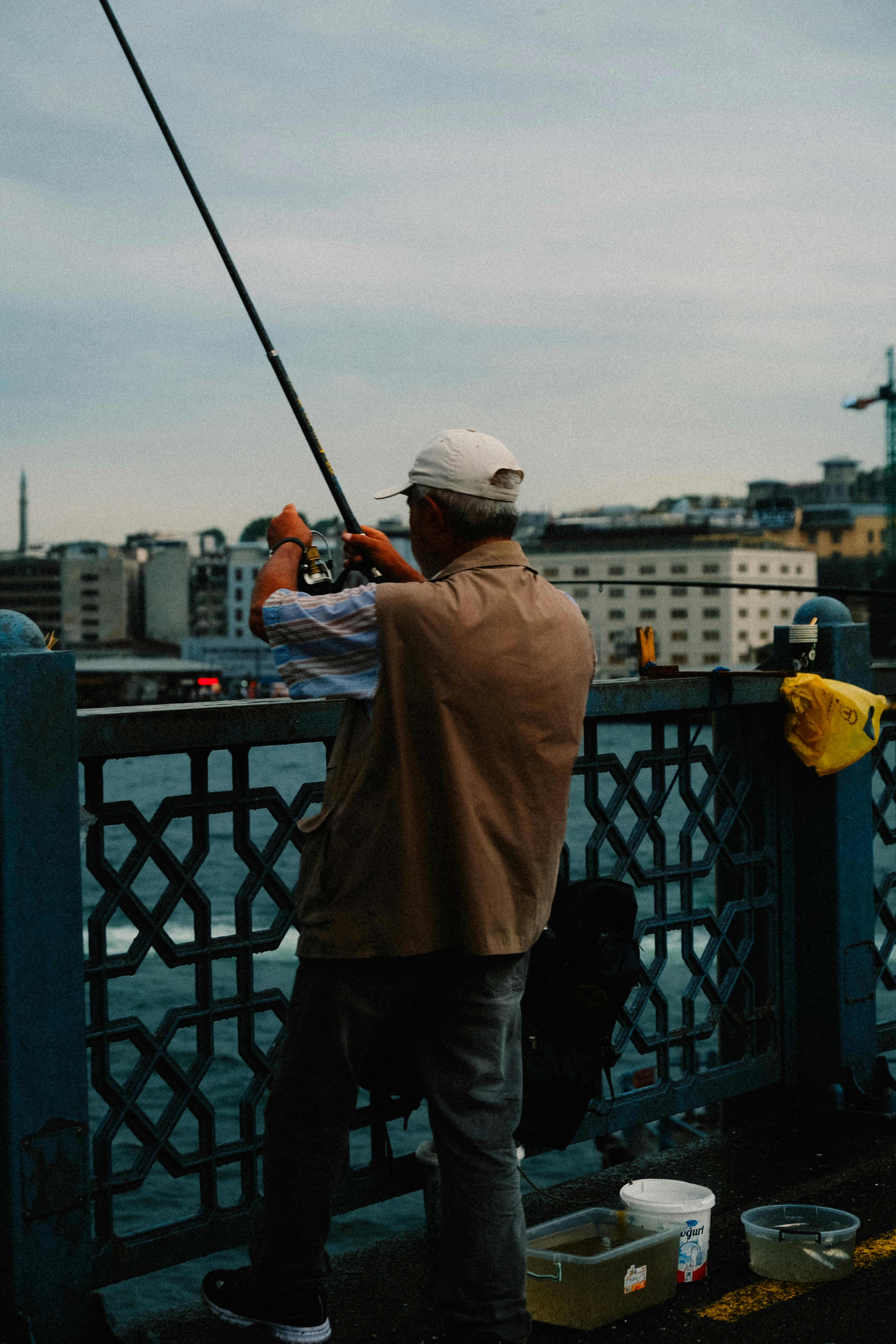 Man Fishing from a Bridge · Free Stock Photo