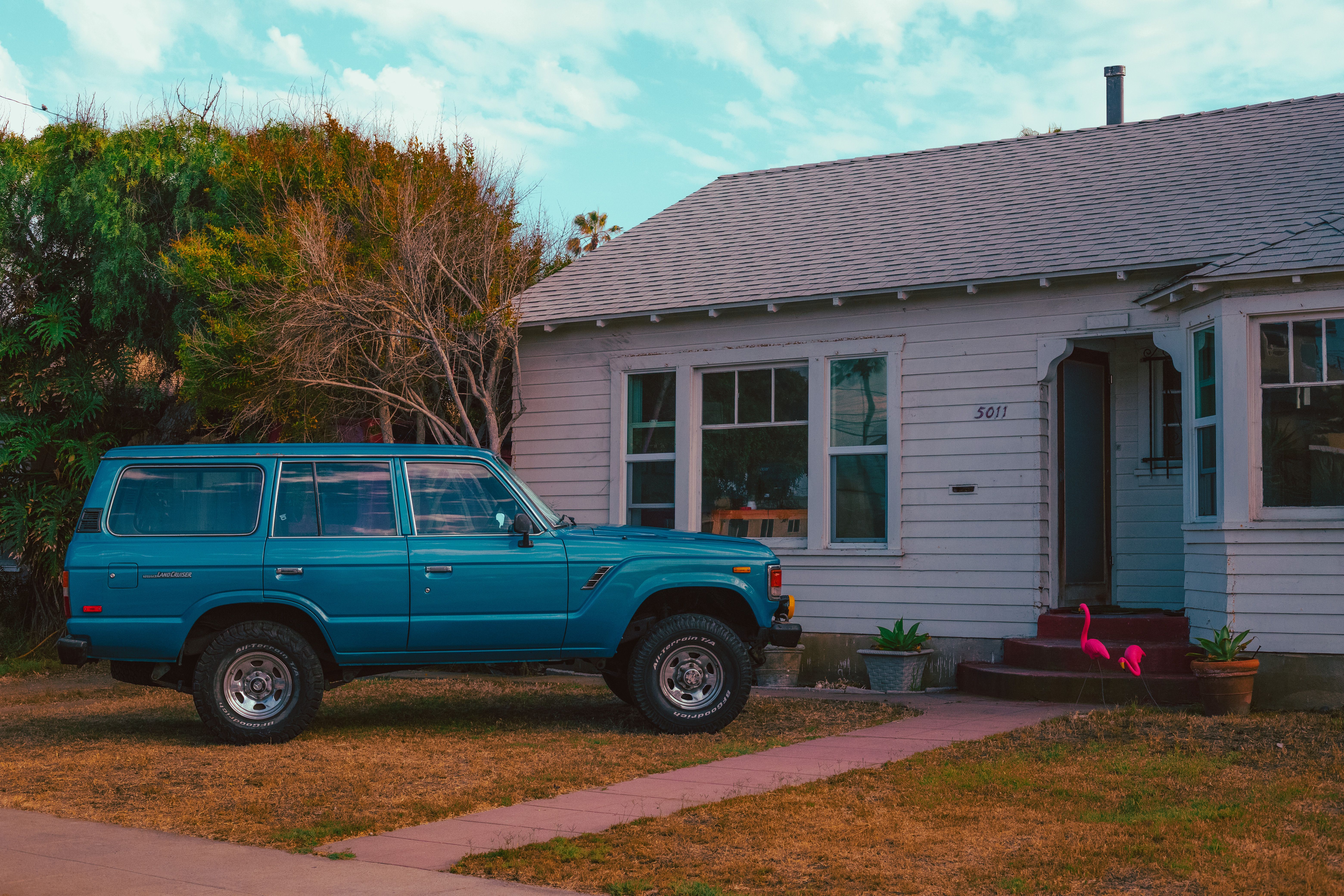 A Blue Land Cruiser Parked Outside a House · Free Stock Photo