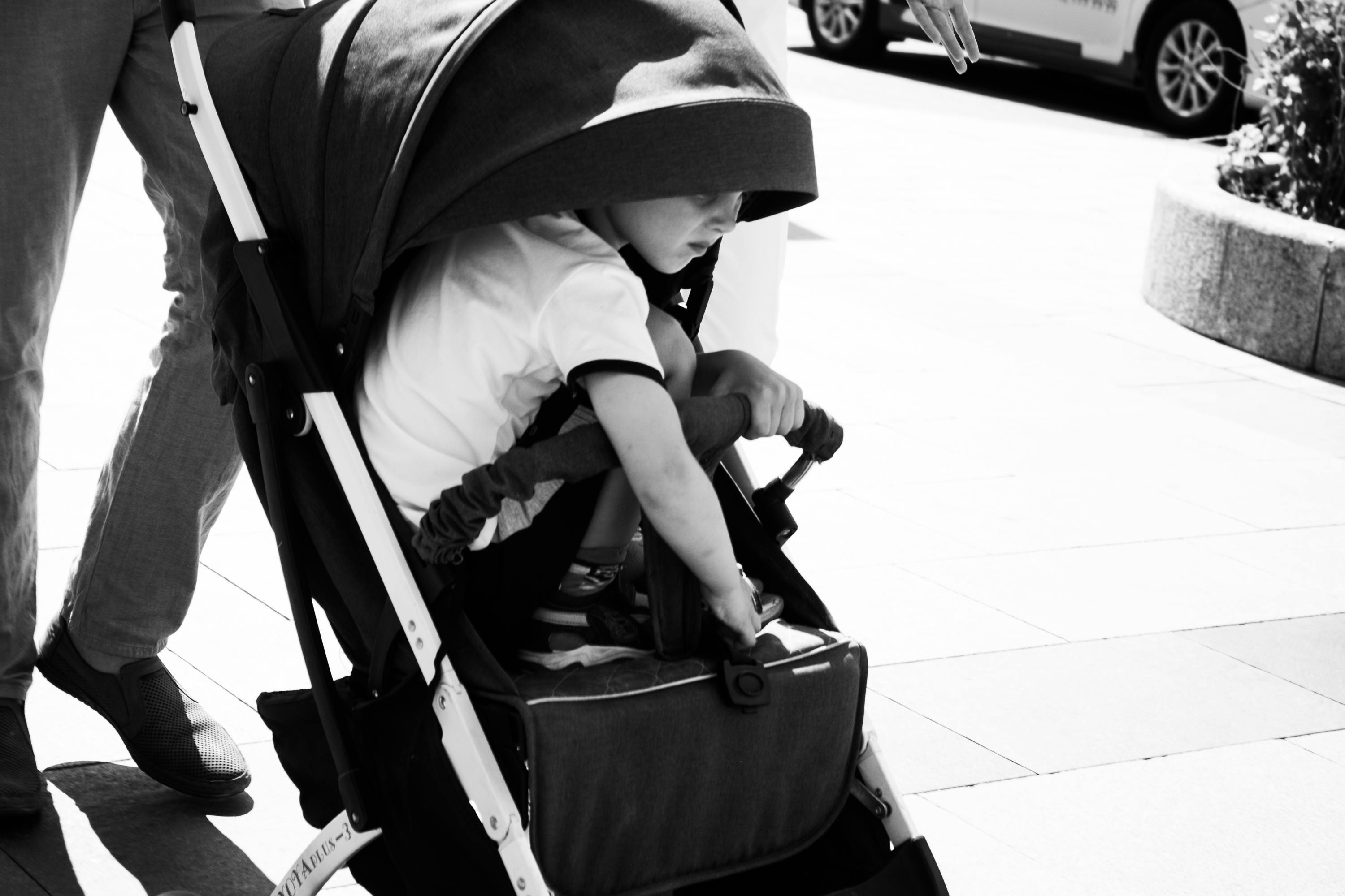 A Child Sitting on the Stroller · Free Stock Photo