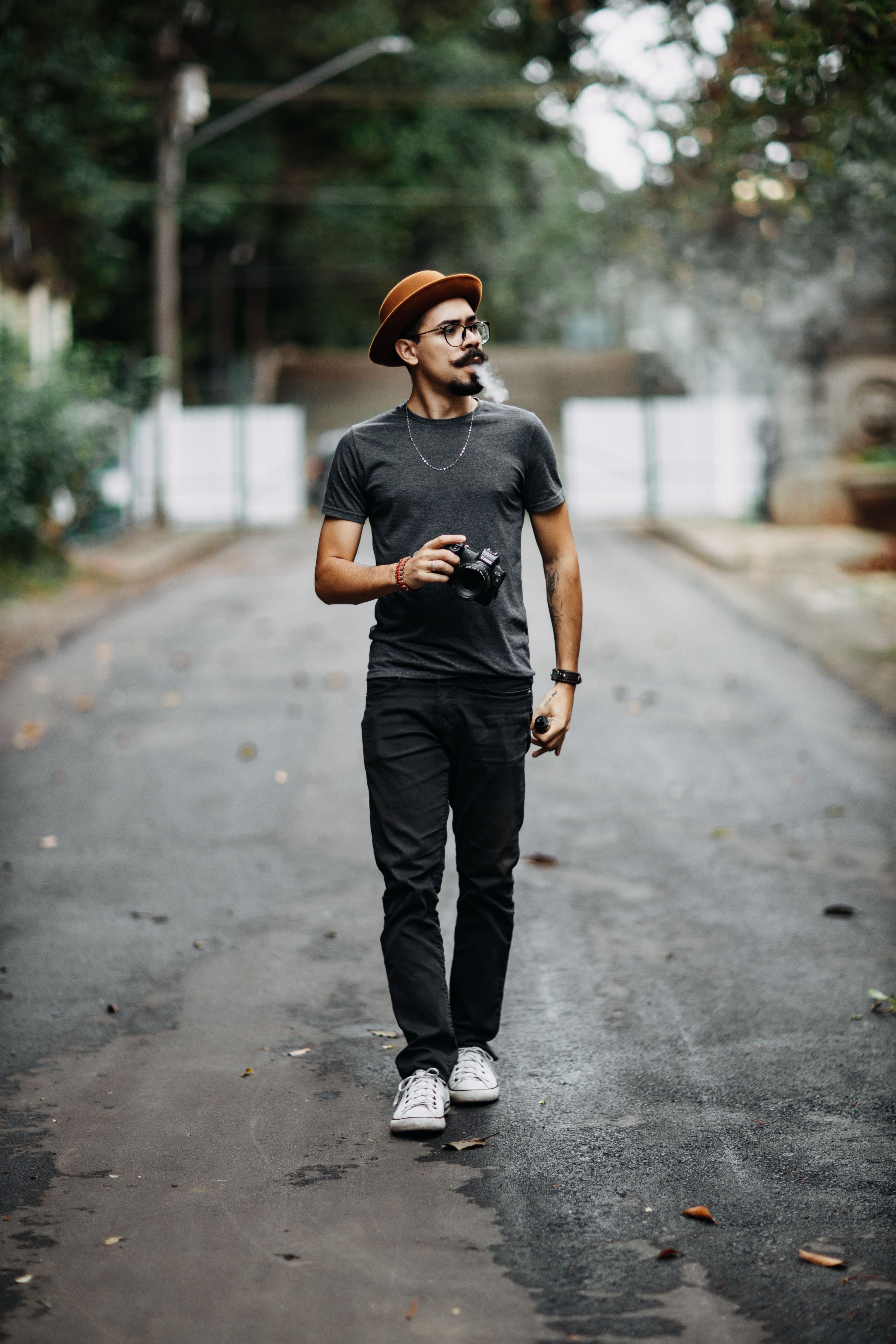 Man Holding a Camera While Walking · Free Stock Photo