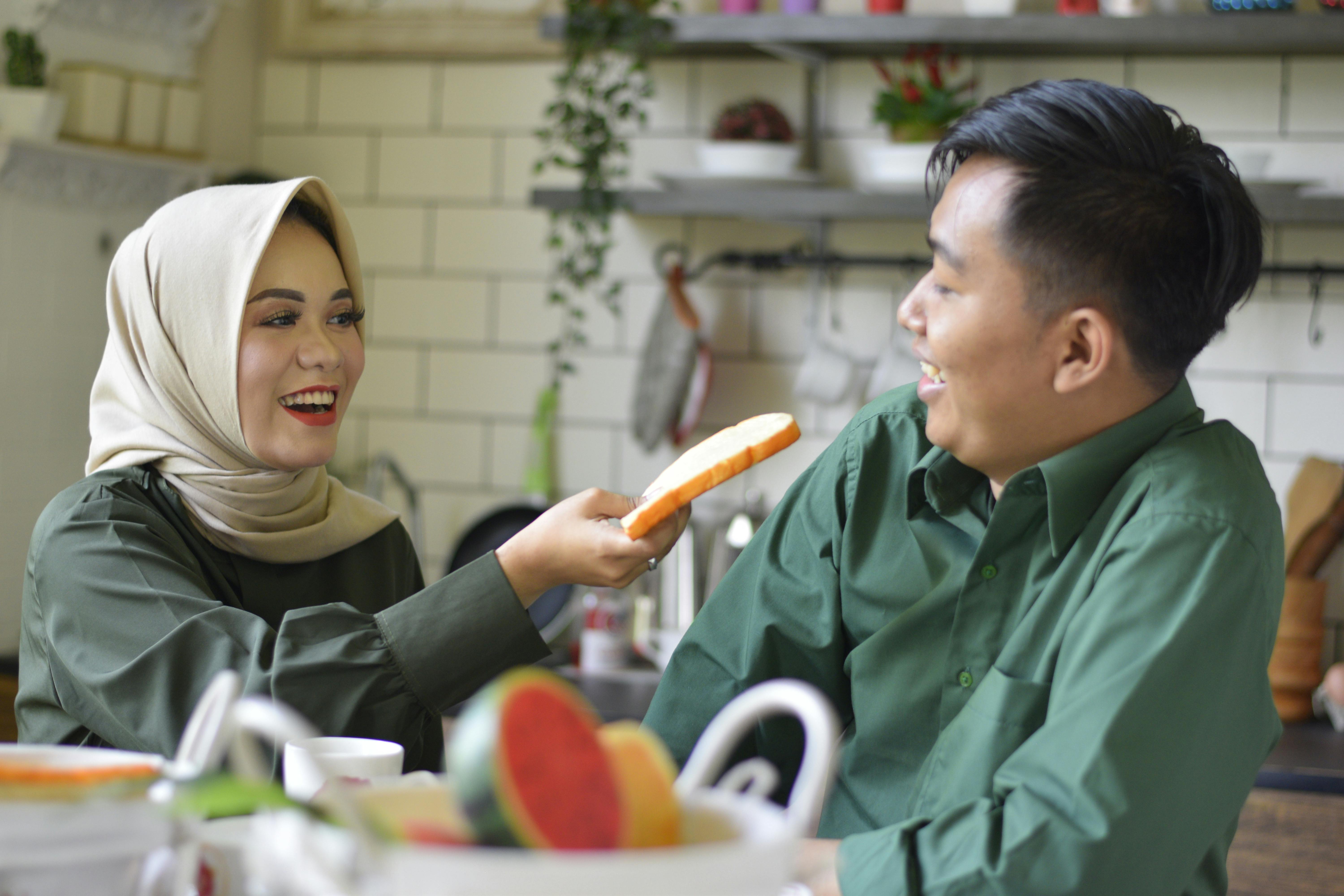 Woman in Green Hijab Removing Eyeglasses of a Man in a Yellow Shirt ...