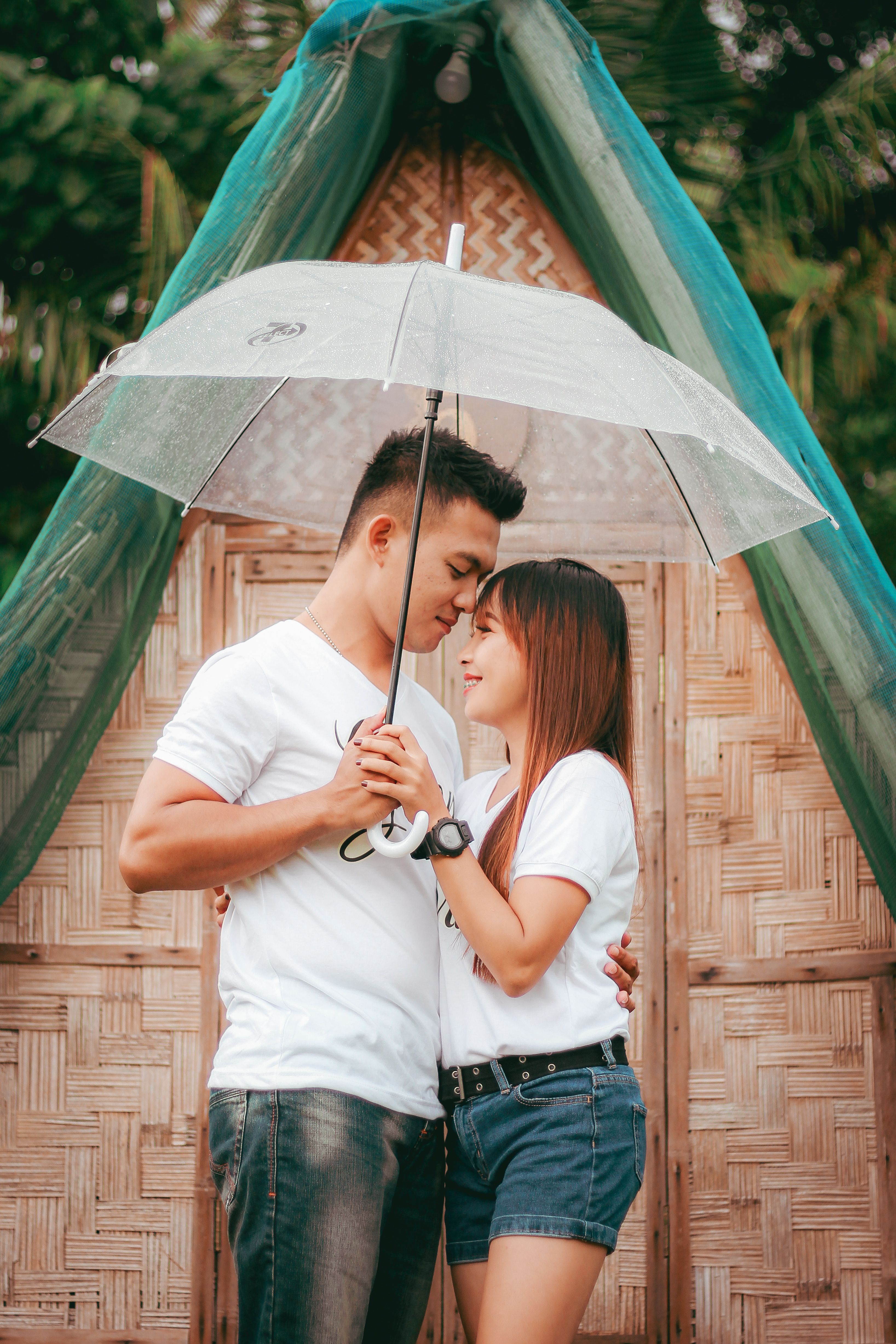 Couple Holding Umbrella Together · Free Stock Photo