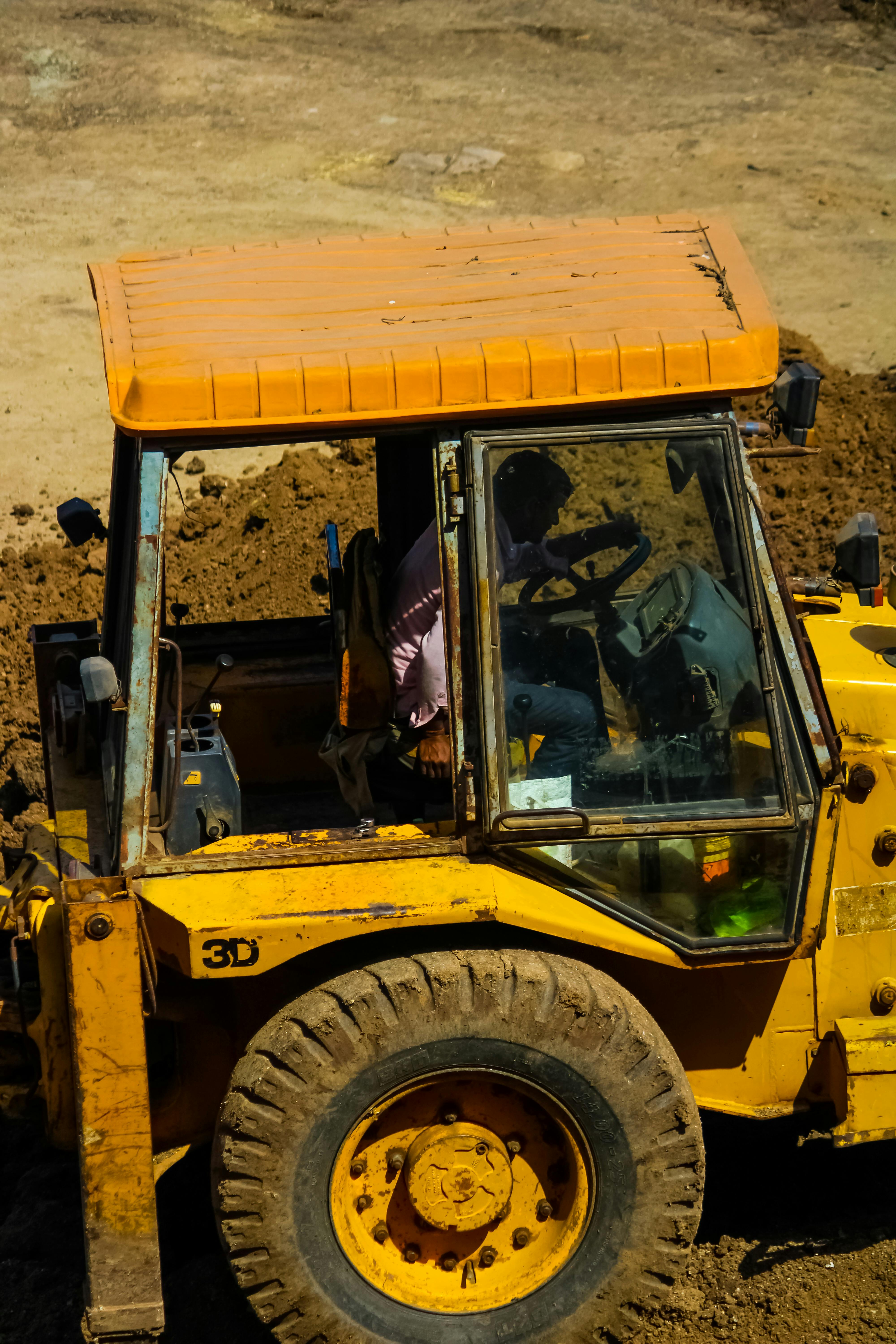 High Angle Photo of Person Walking Near Backhoe · Free Stock Photo
