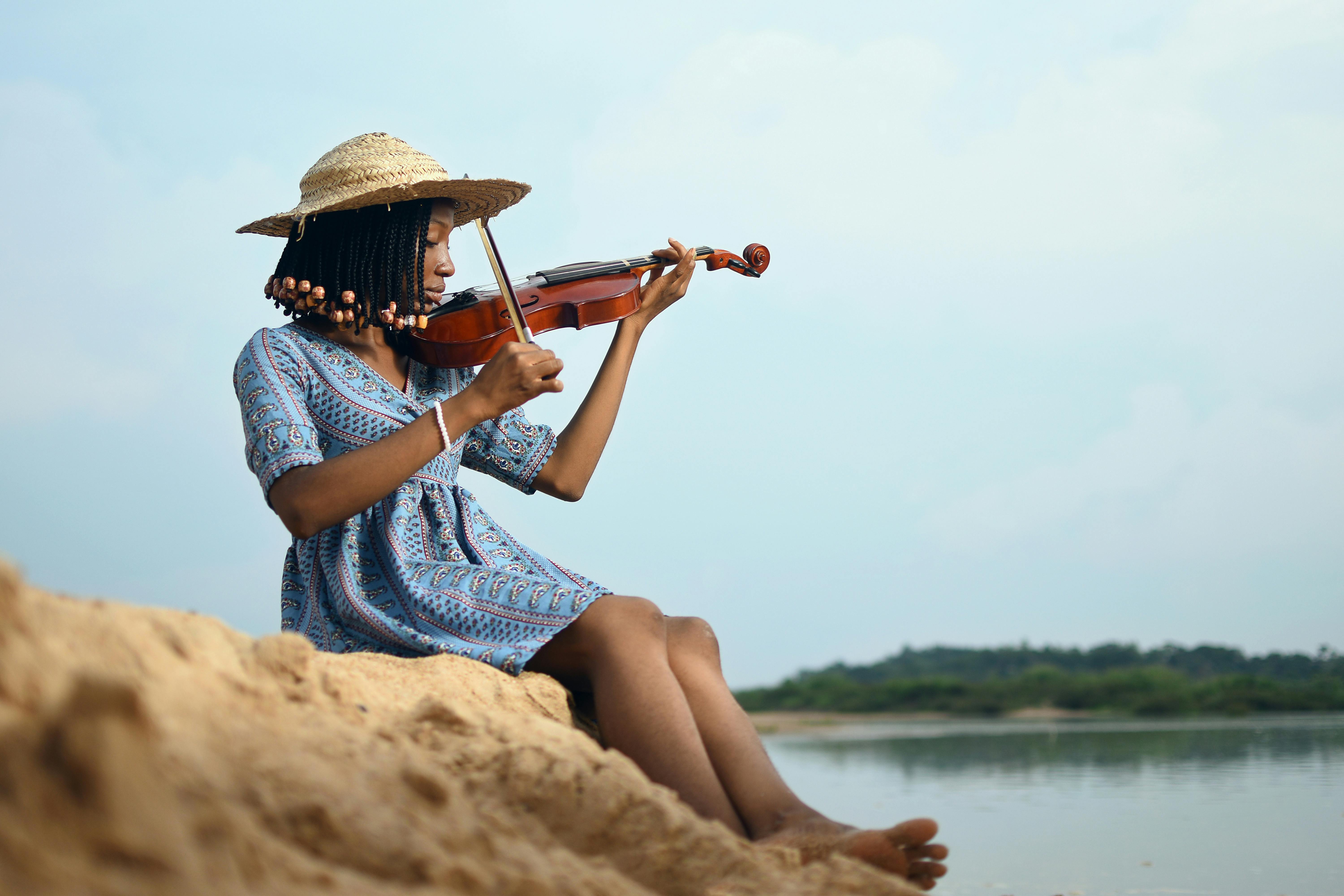 Low-Angle Shot of a Woman in Blue Dress Playing Violin · Free Stock Photo