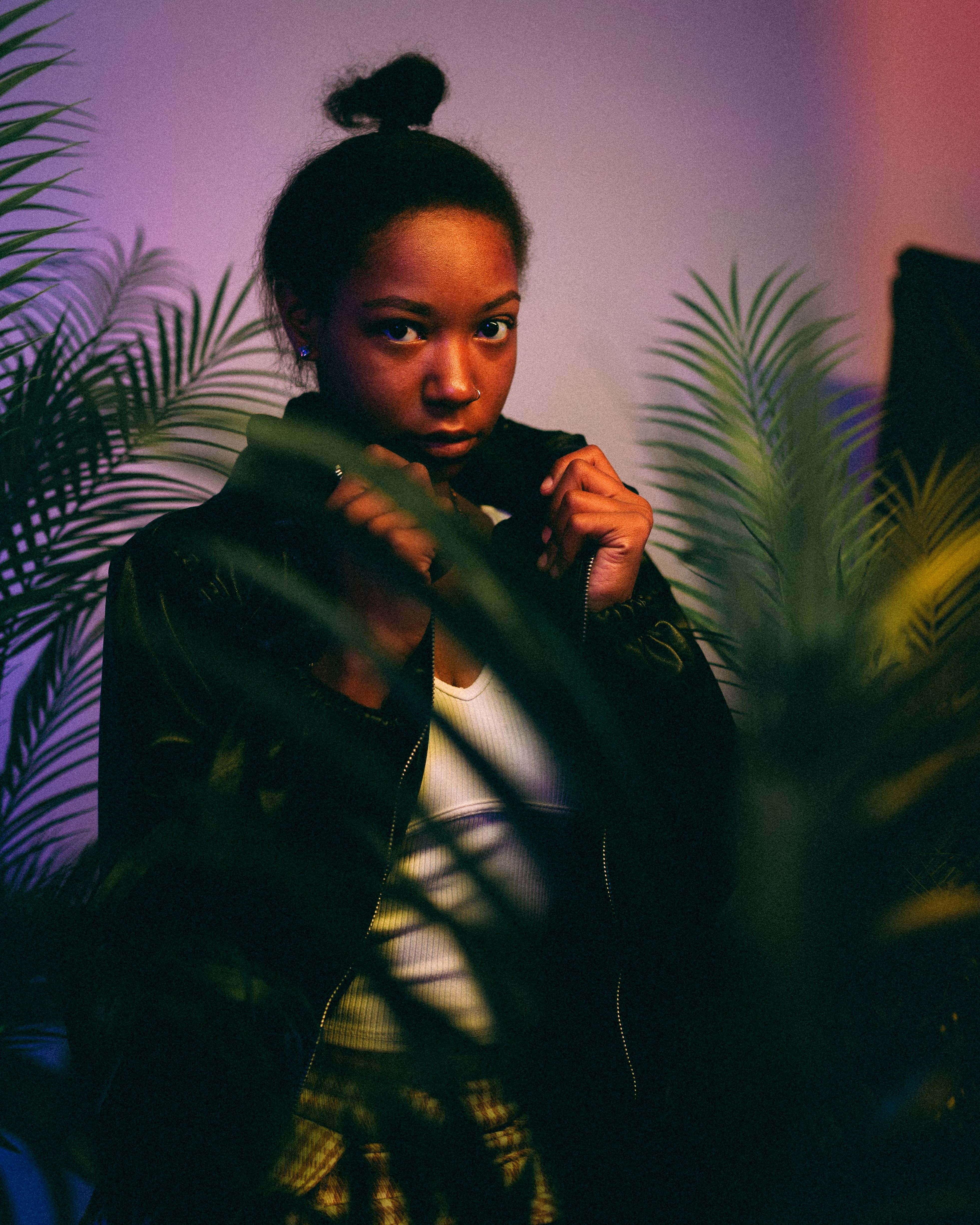 Woman in Black Leather Jacket Standing Near Plants · Free Stock Photo