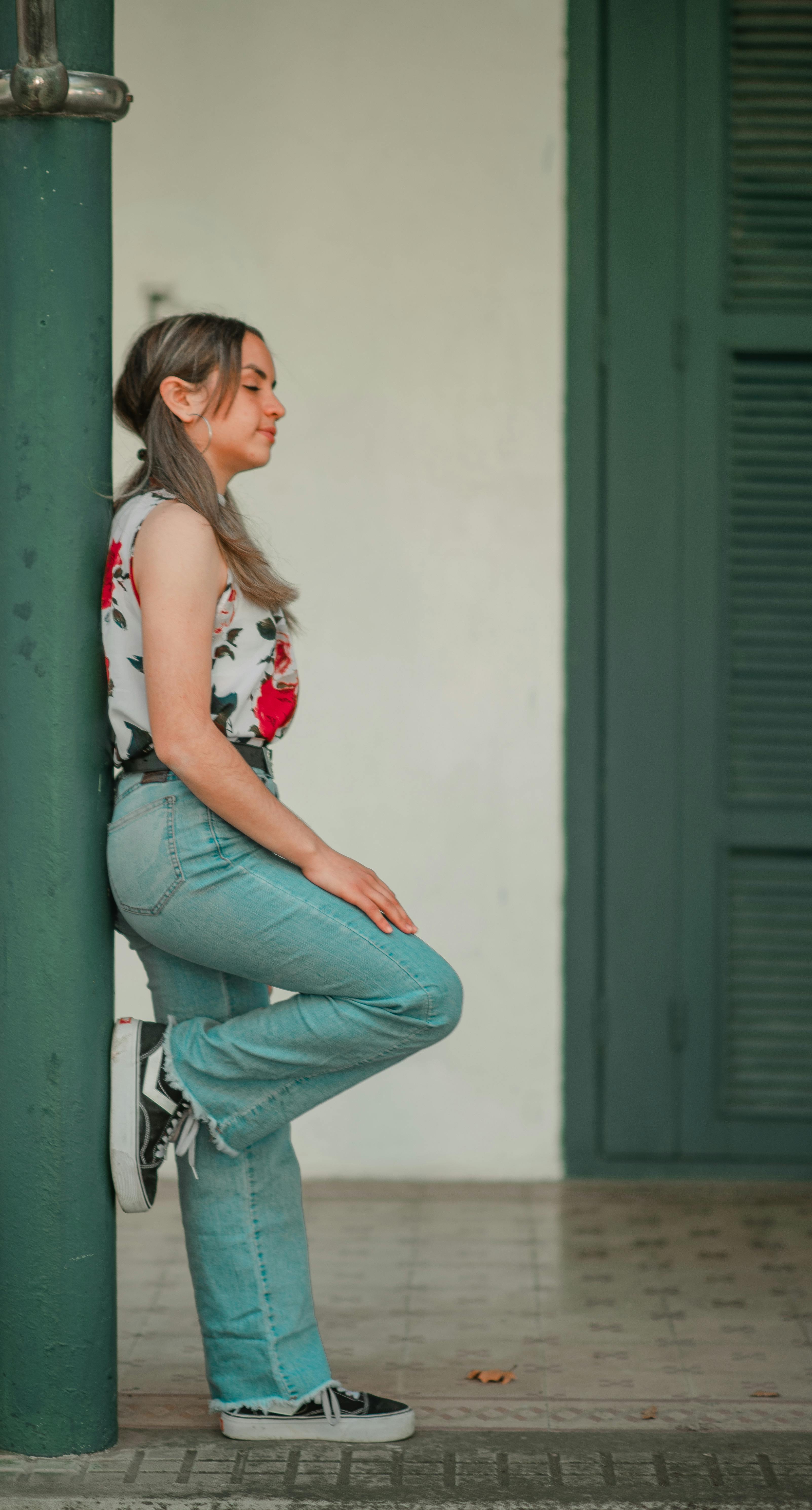 Pretty Woman Leaning on a Steel Post · Free Stock Photo