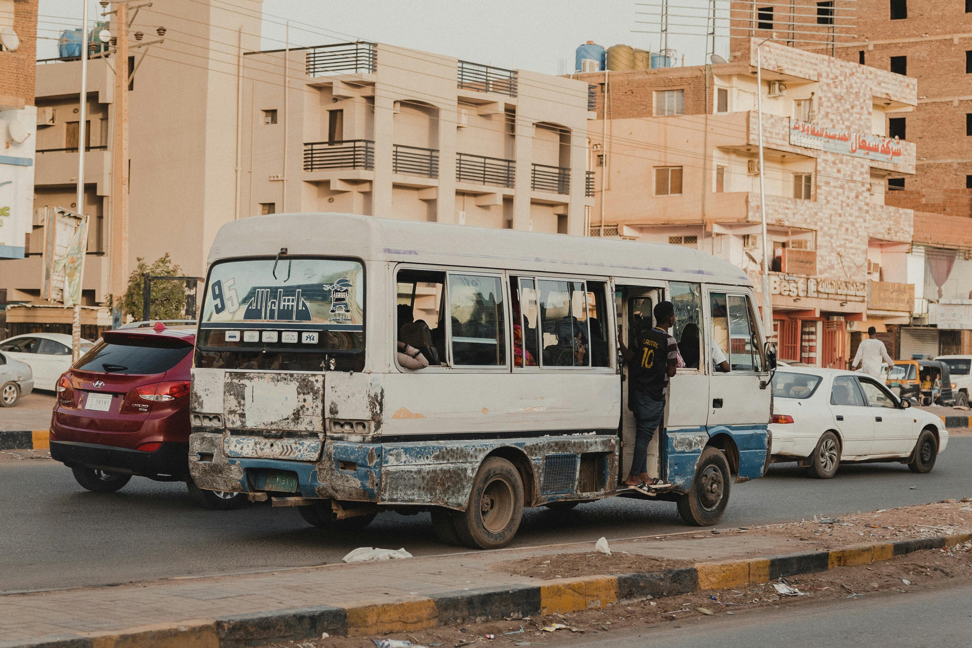 Man Riding Bus on Poor City Street · Free Stock Photo
