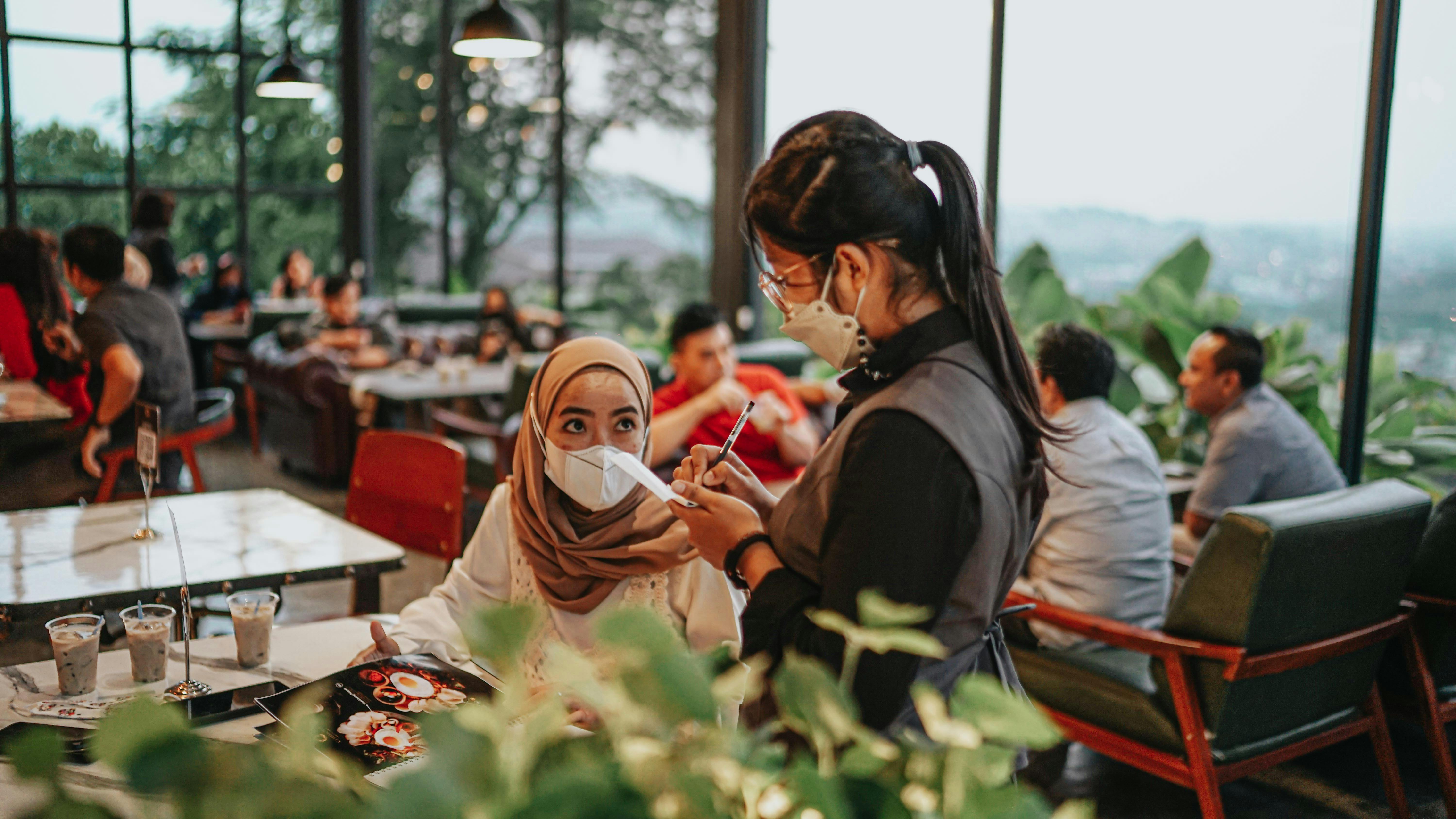A Woman in Brown Hijab Ordering Food in the Restaurant · Free Stock Photo