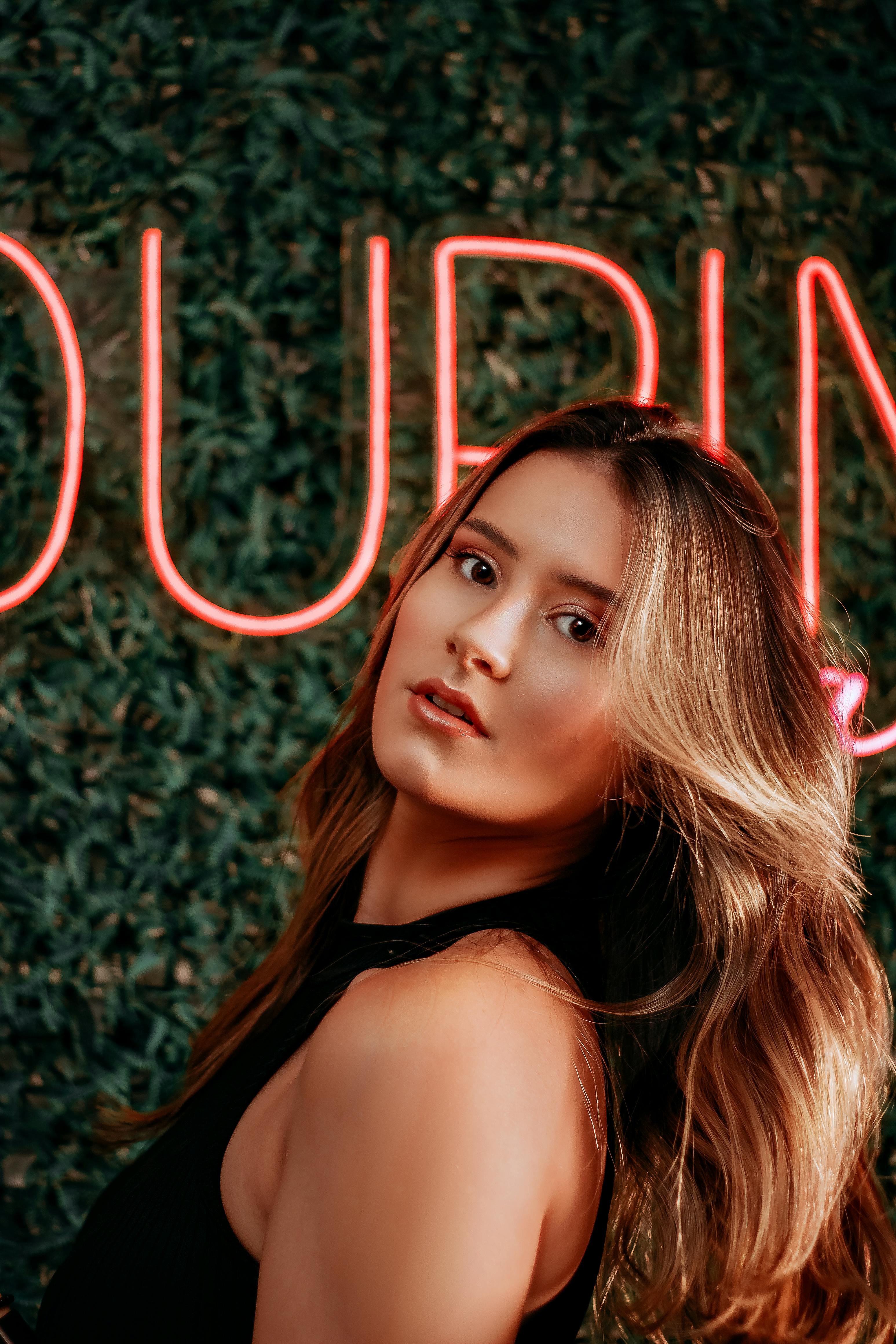 A Women with a Trendy Hairstyle Sitting at a Table · Free Stock Photo