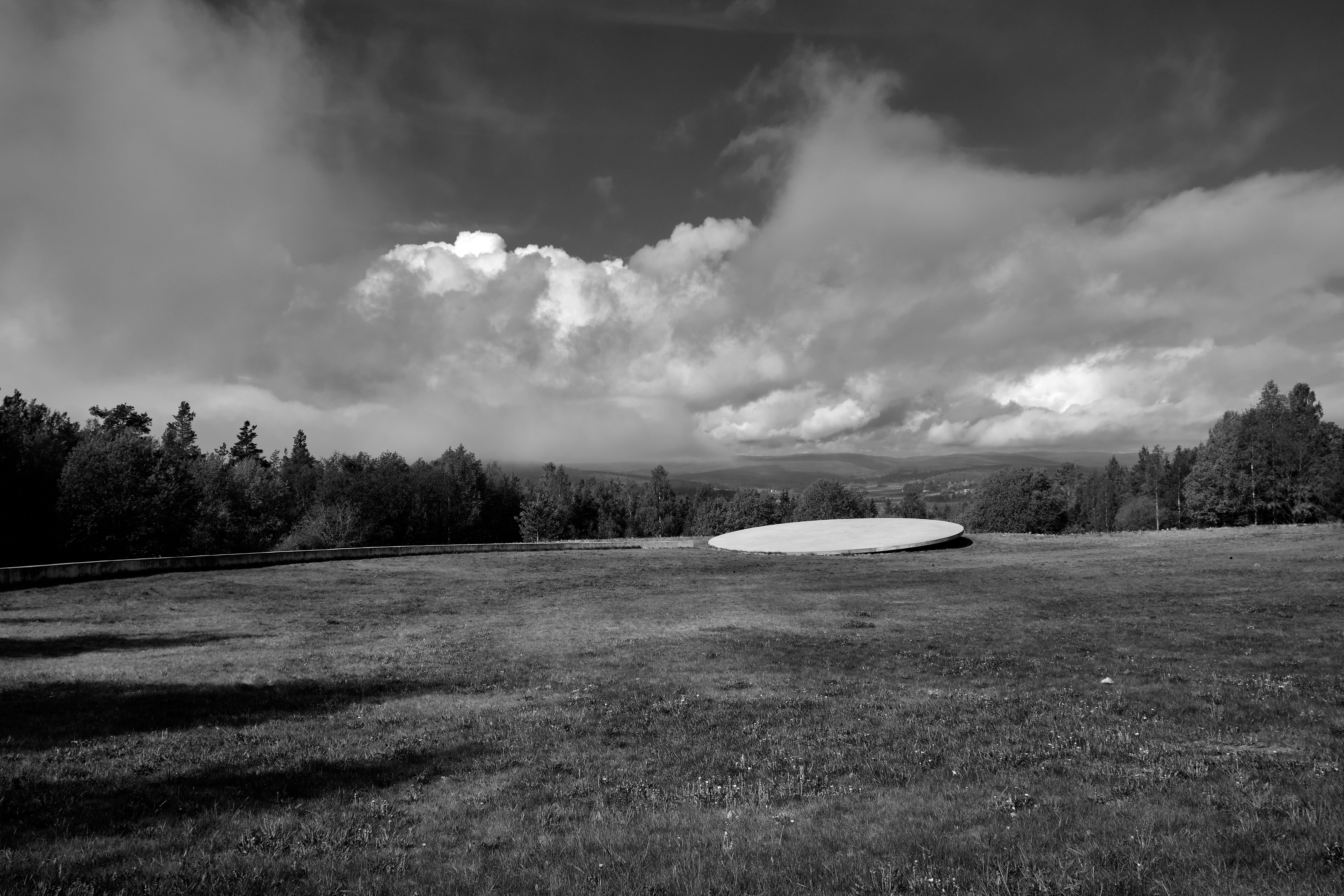 A Grayscale Photo of a Grass Field Under the Cloudy Sky · Free Stock Photo