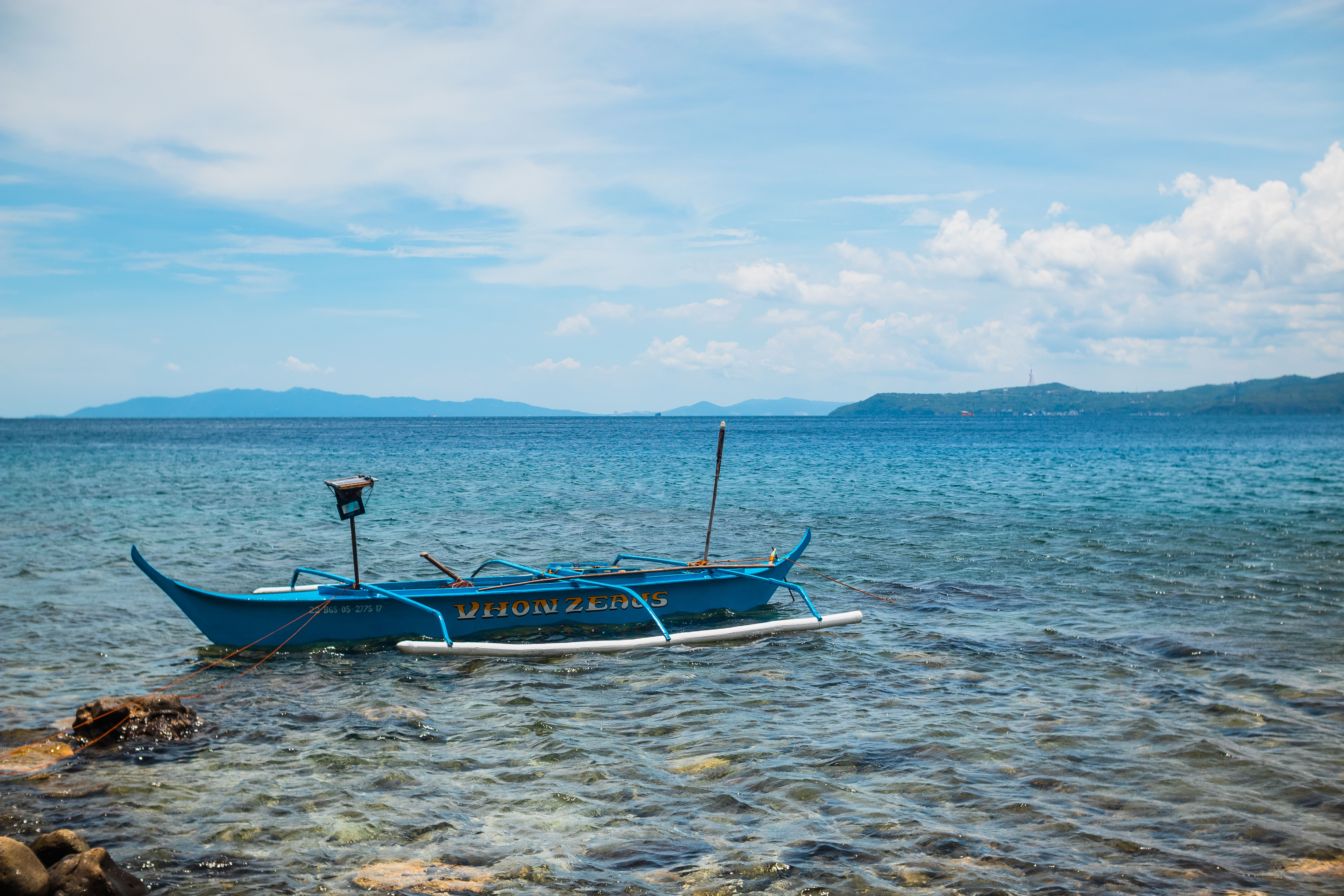 Blue Boat Floating in the Ocean · Free Stock Photo