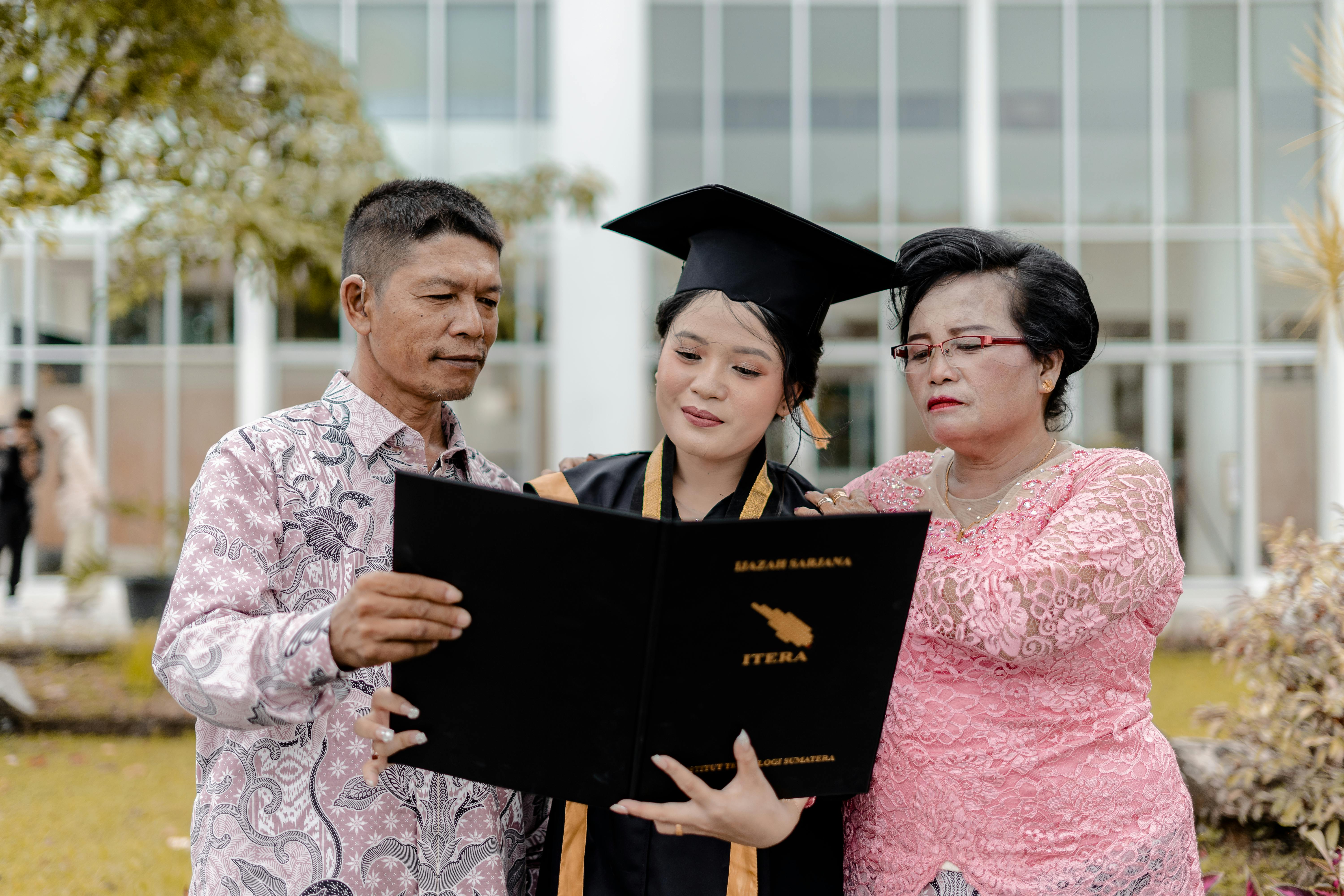 Photo of a Man Wearing Academic Gown Together with His Parents · Free Stock Photo