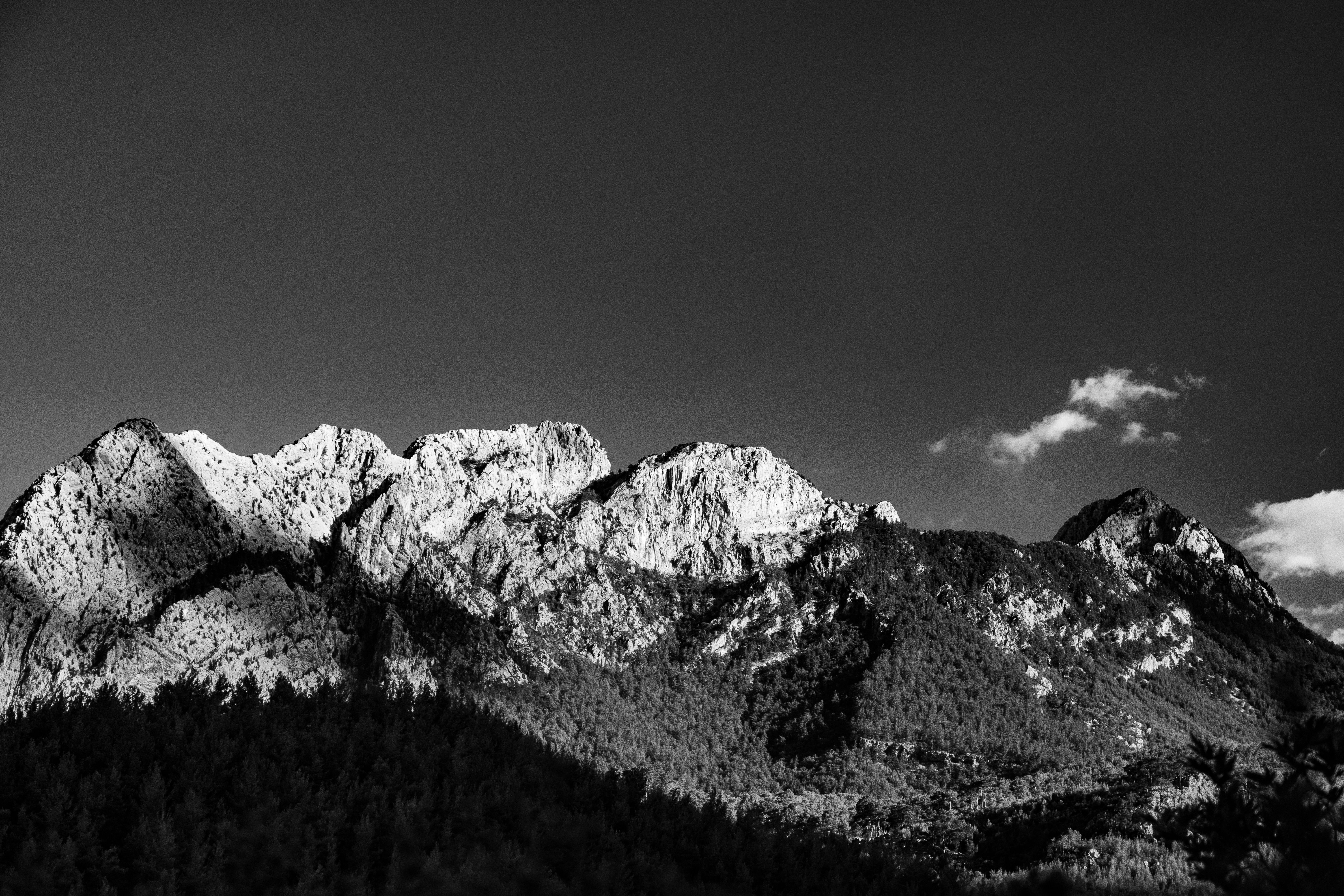 A Grayscale Photo of a Mountain Under the Dark Sky · Free Stock Photo
