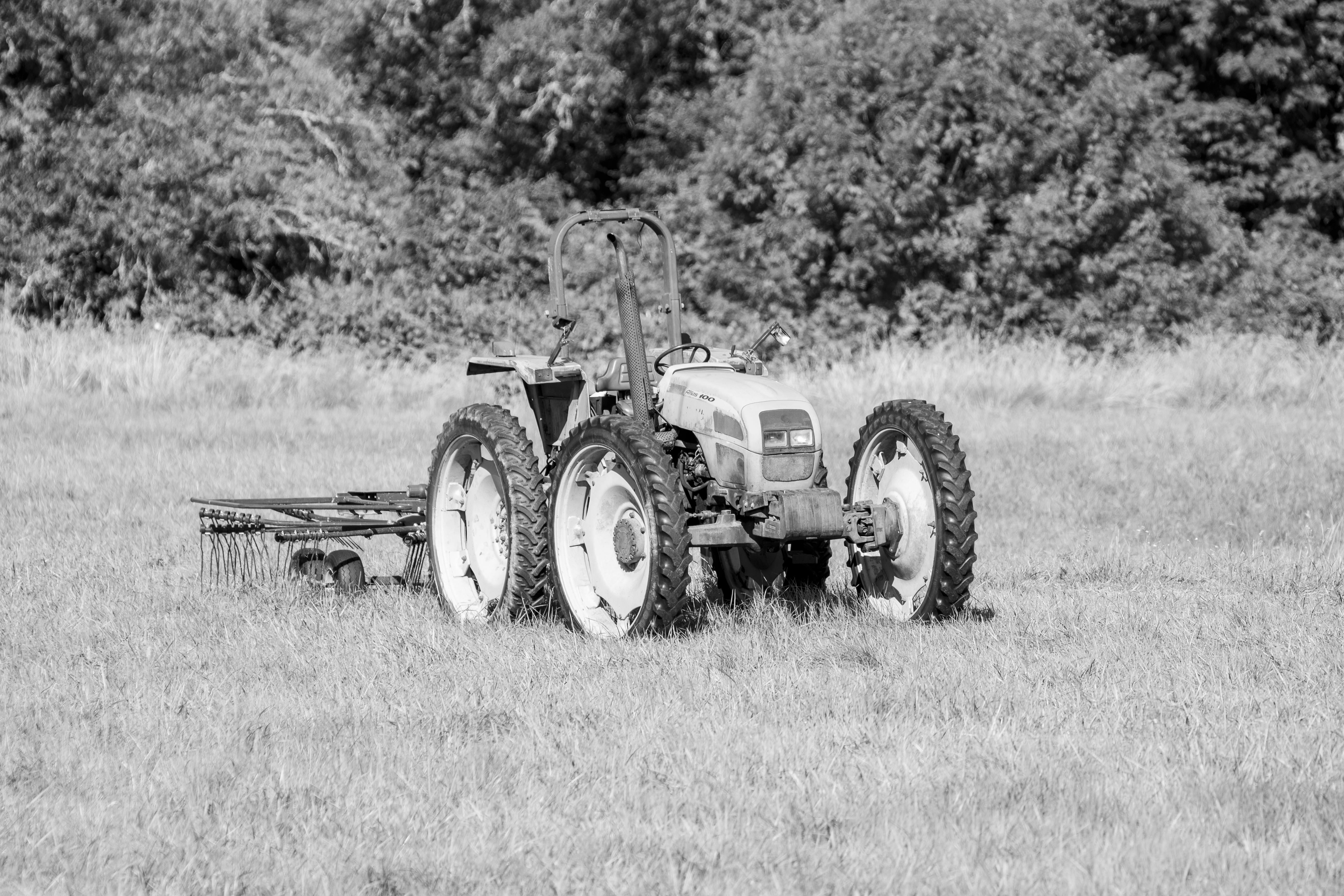 A Grayscale Photo of a Tractor on the Field · Free Stock Photo