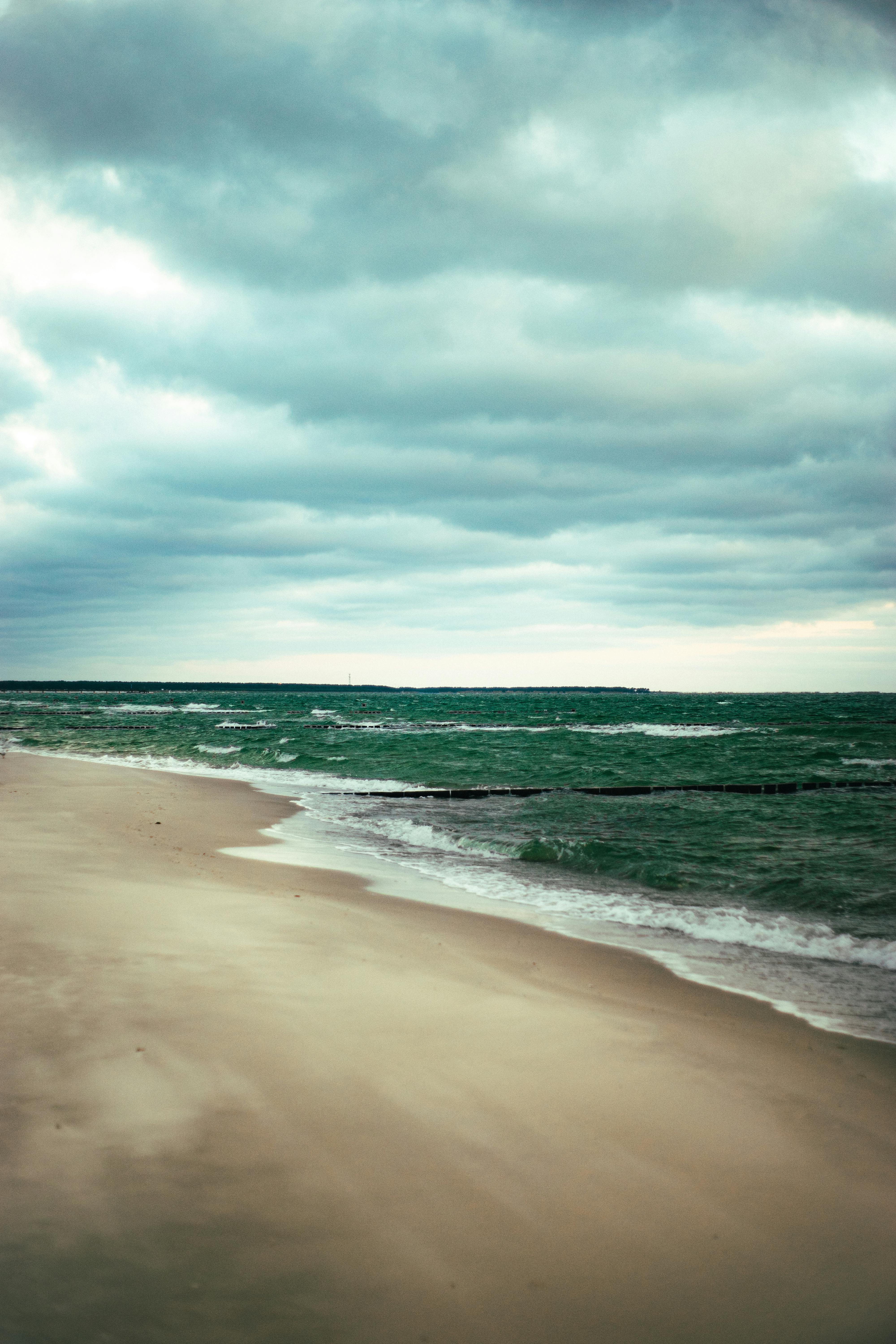 Serene Sandy Beach with Calm Ocean Waves · Free Stock Photo
