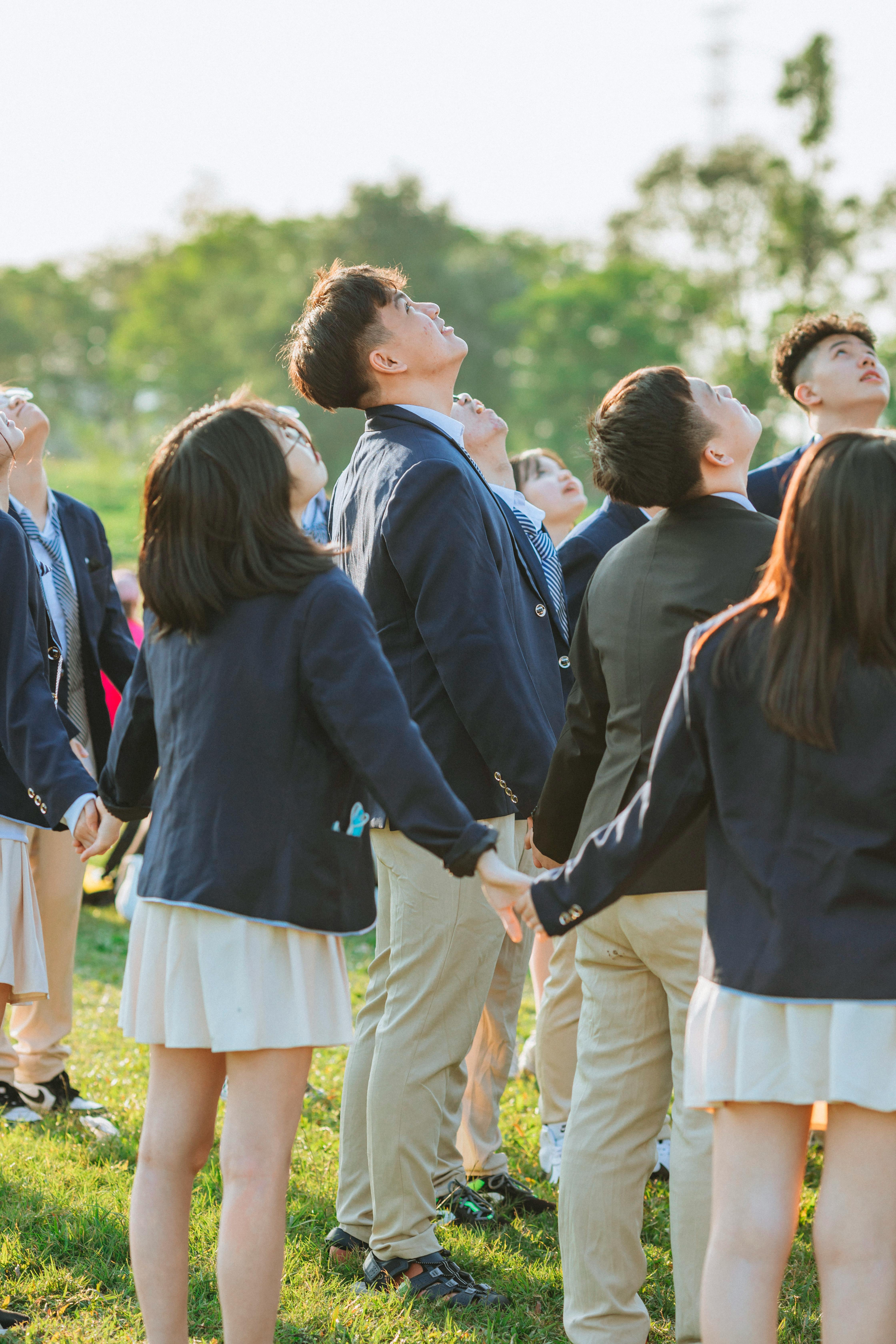 A Group of Students Wearing Navy Blue Coat Looking Up to The Sky · Free ...