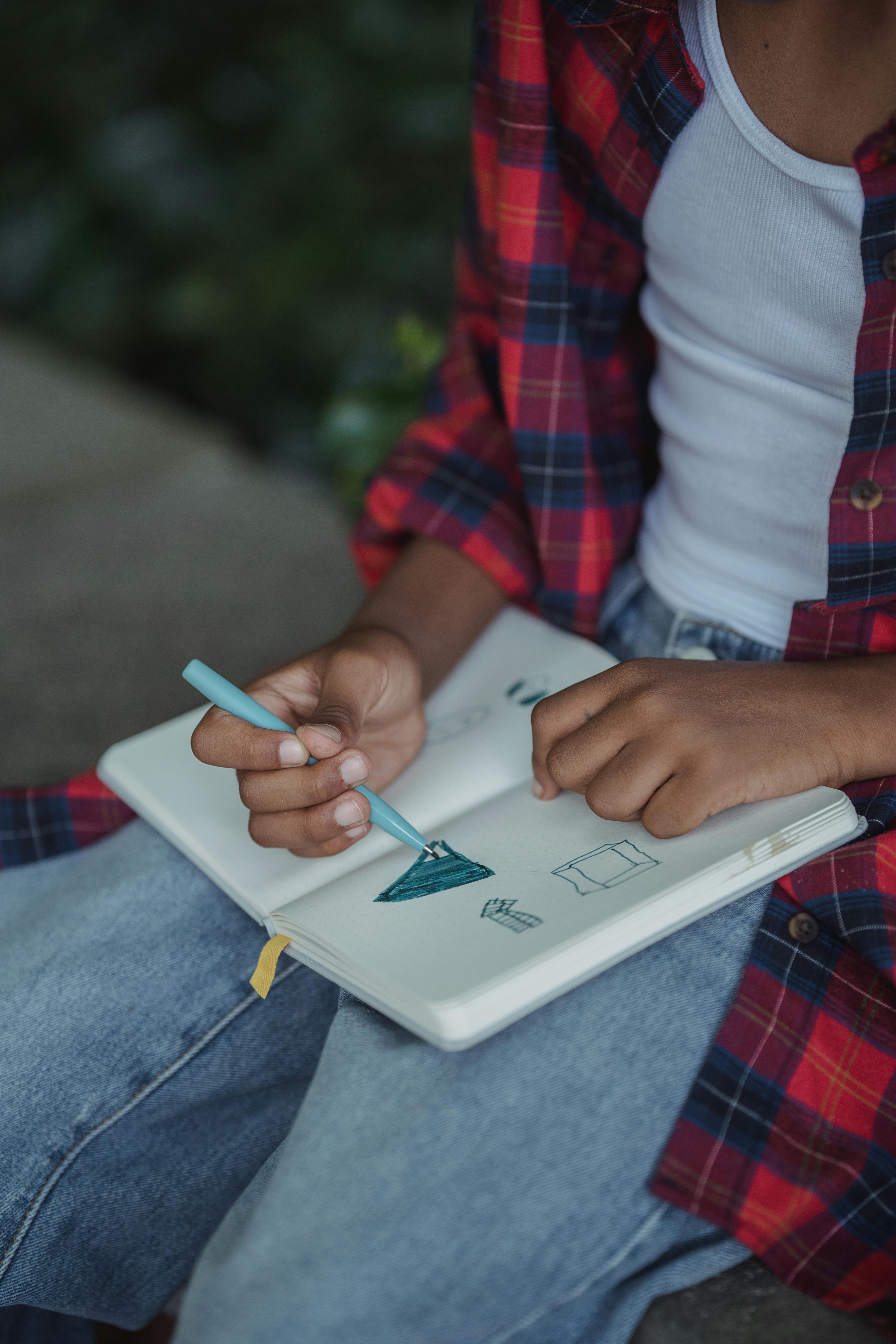 Child Drawing in Notebook · Free Stock Photo