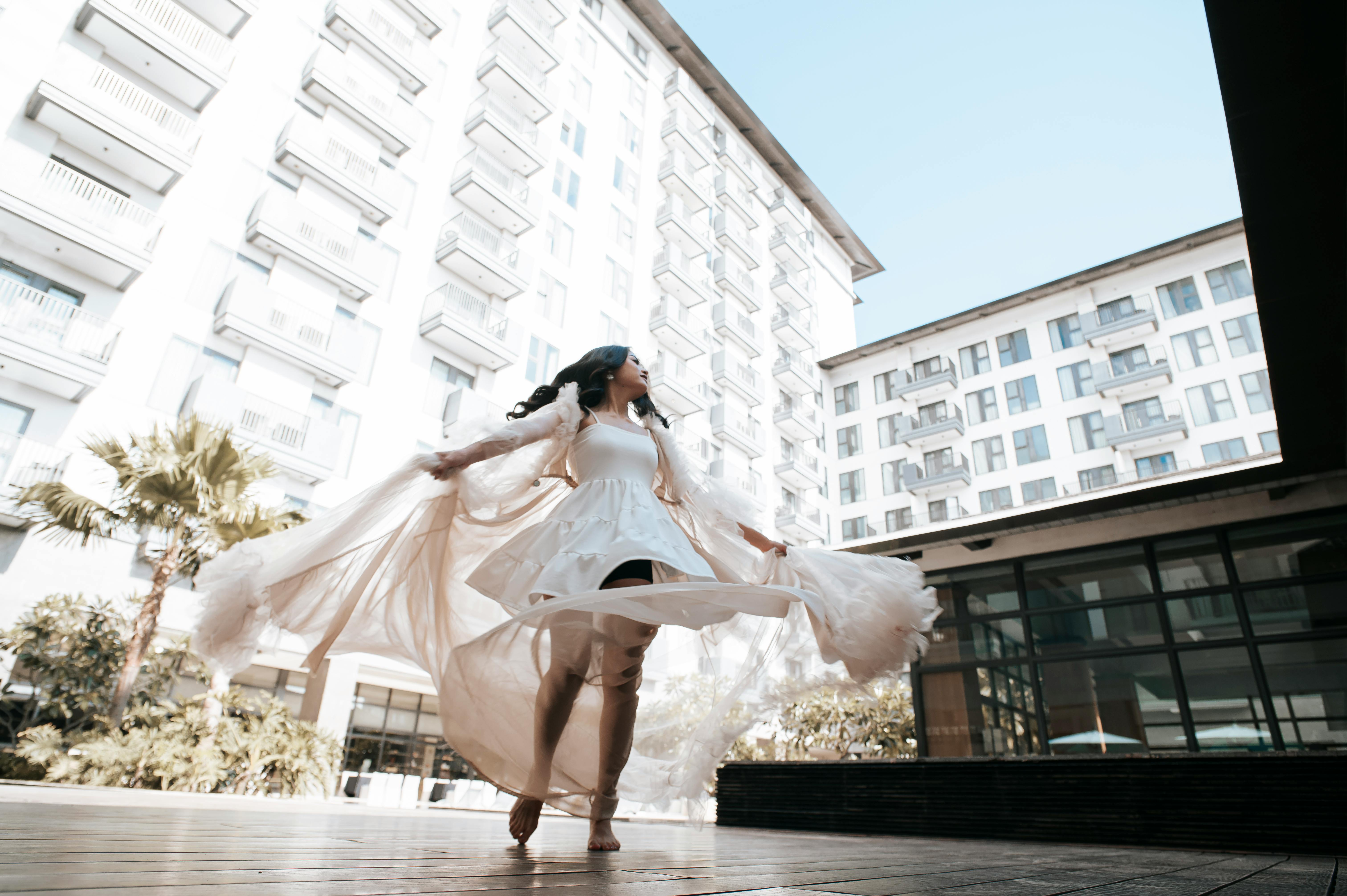 A Woman in Red Dress Dancing on a Ledge · Free Stock Photo