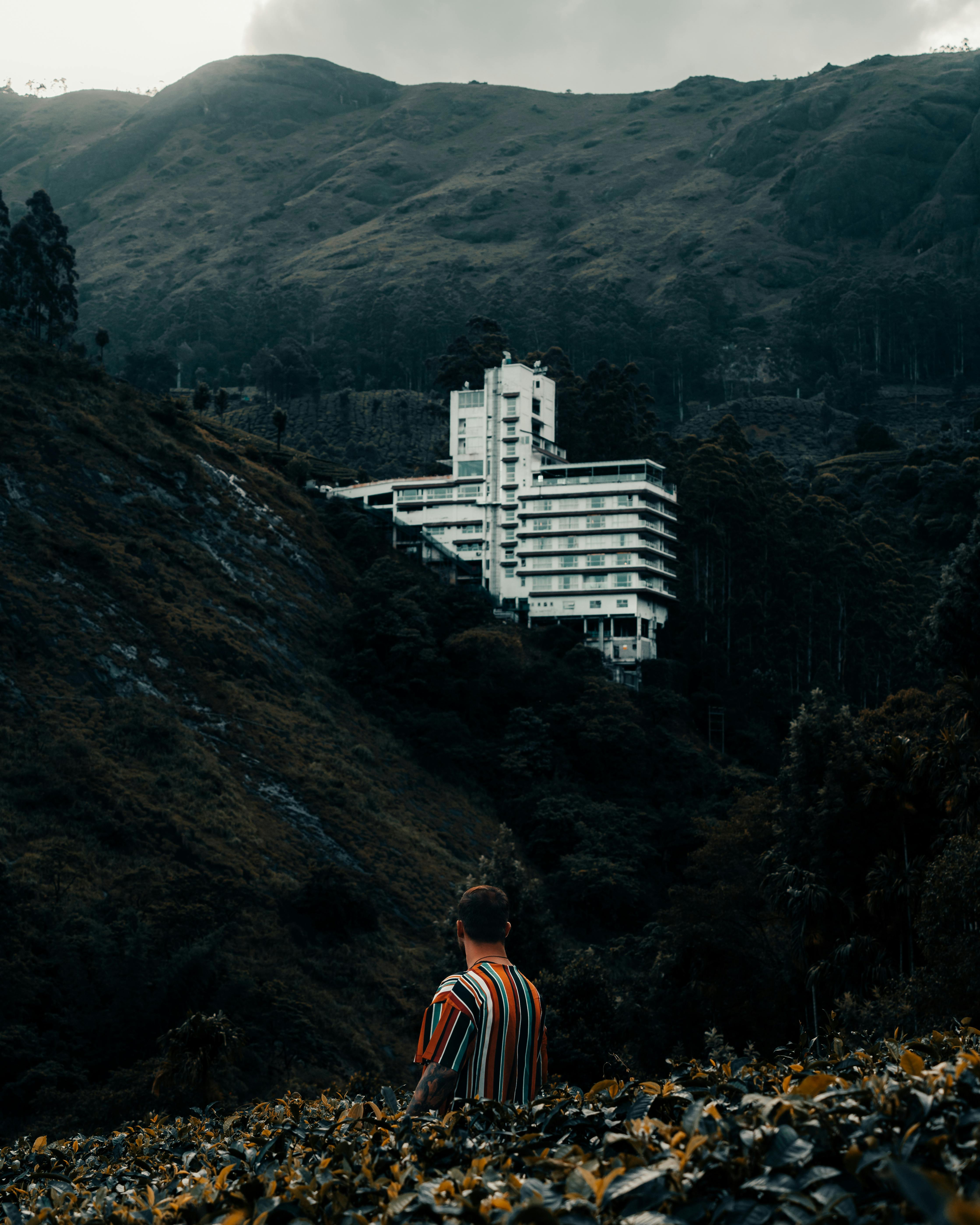 A Person Looking at a Building on the Mountain · Free Stock Photo