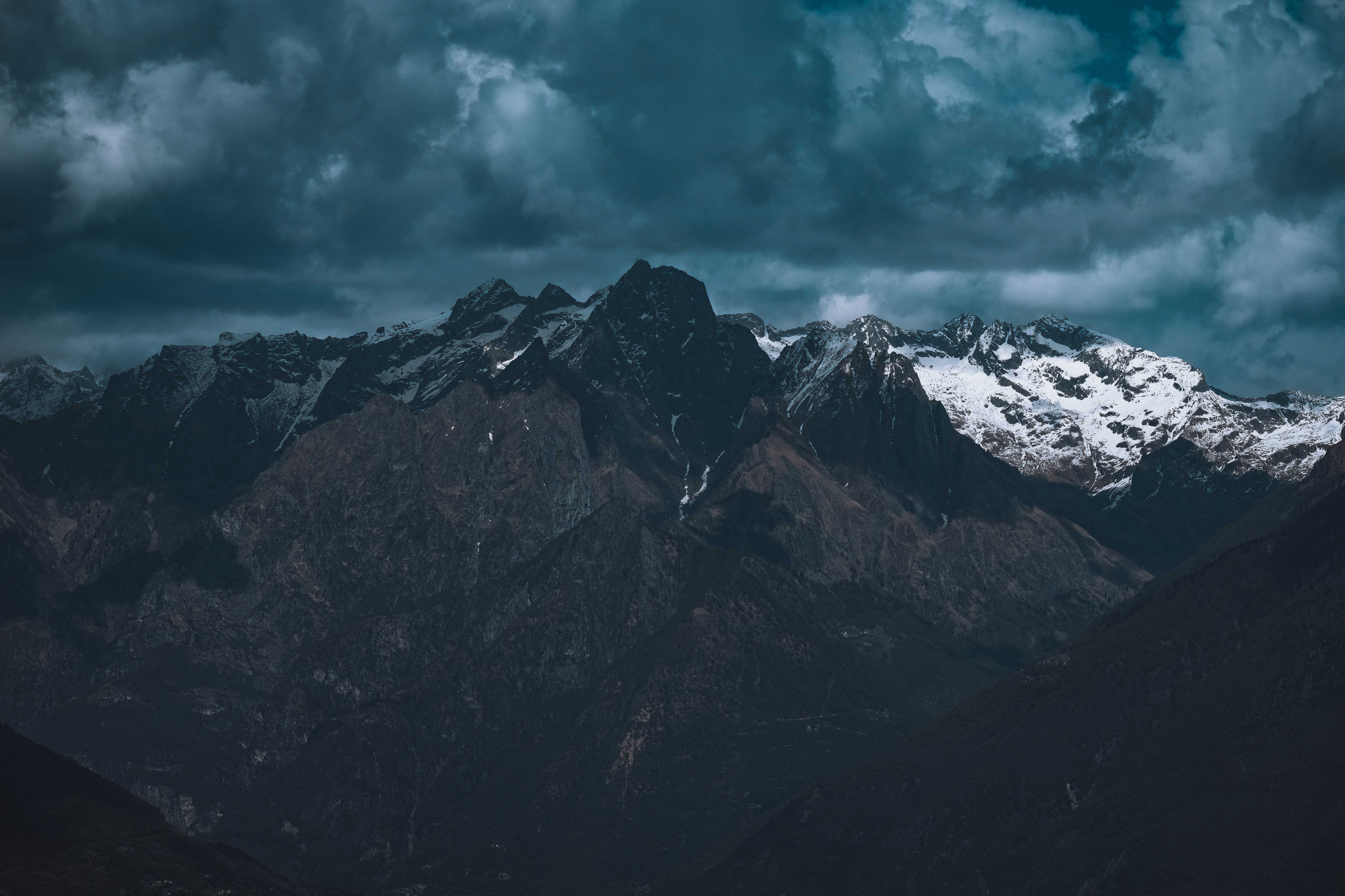A View of Snow Capped Mountains under a Gloomy Sky · Free Stock Photo