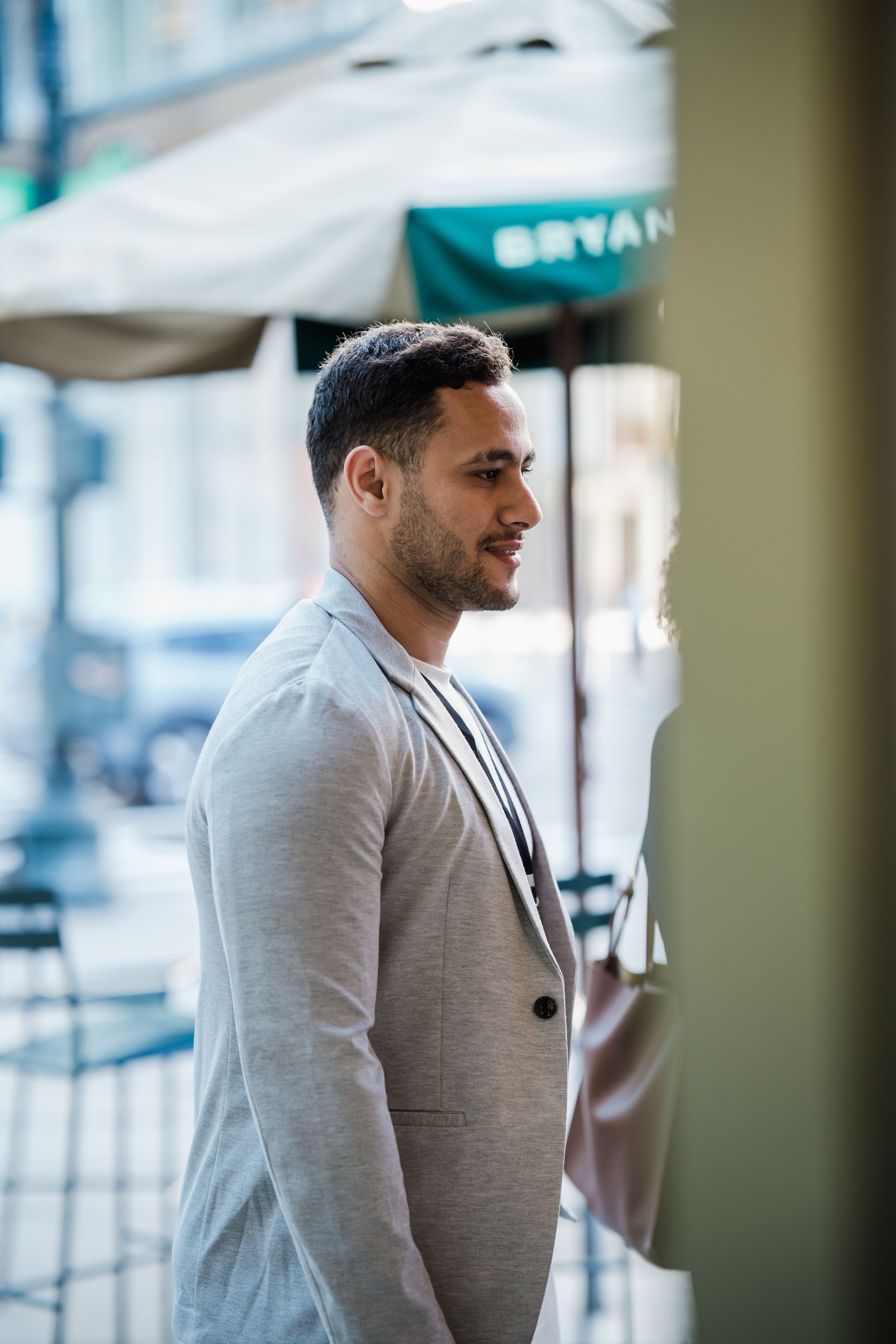 Elegantly Dressed Man Standing in Front of a Cafe · Free Stock Photo