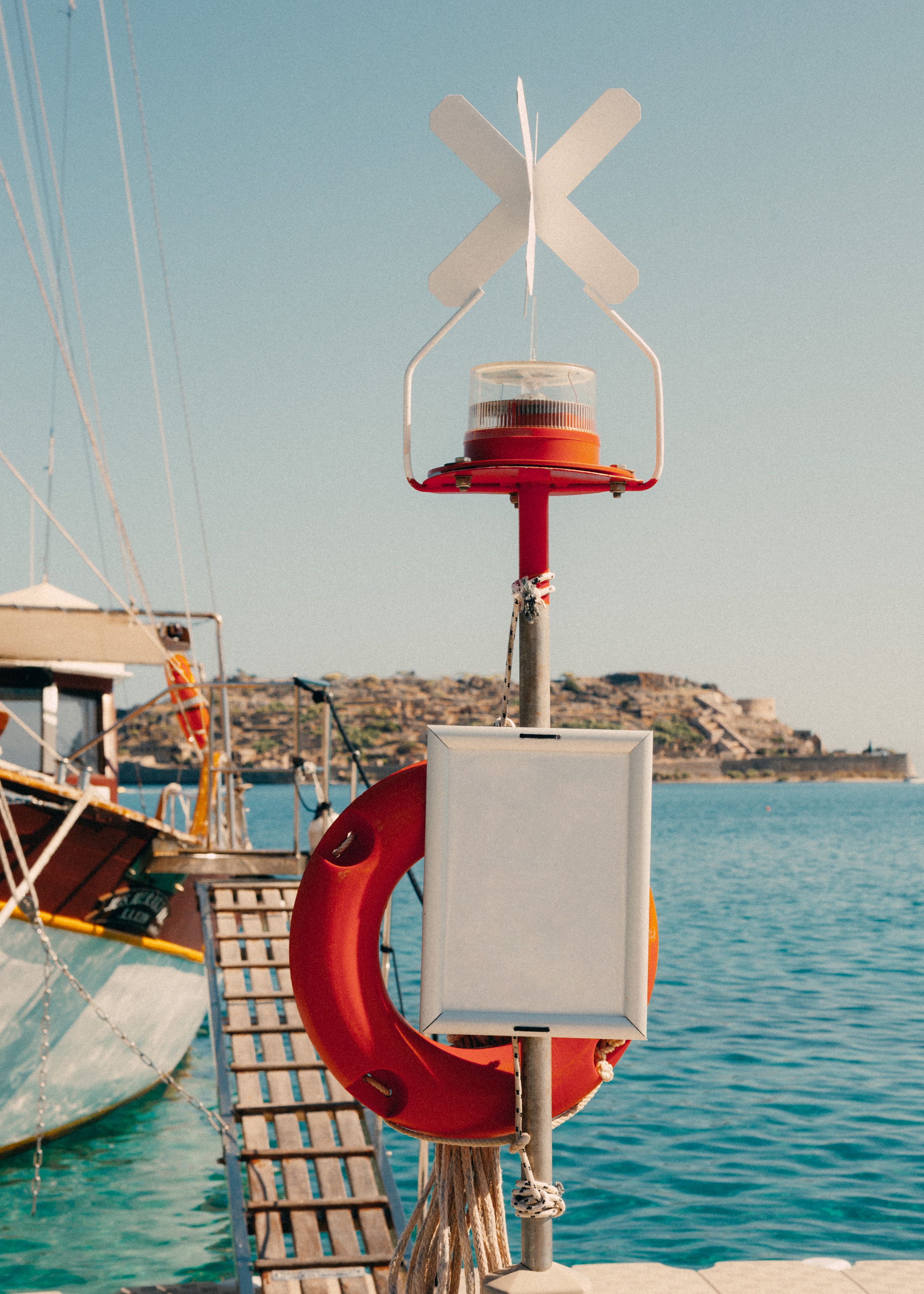 Pole with Life Buoy and Boardwalk to Boat behind · Free Stock Photo
