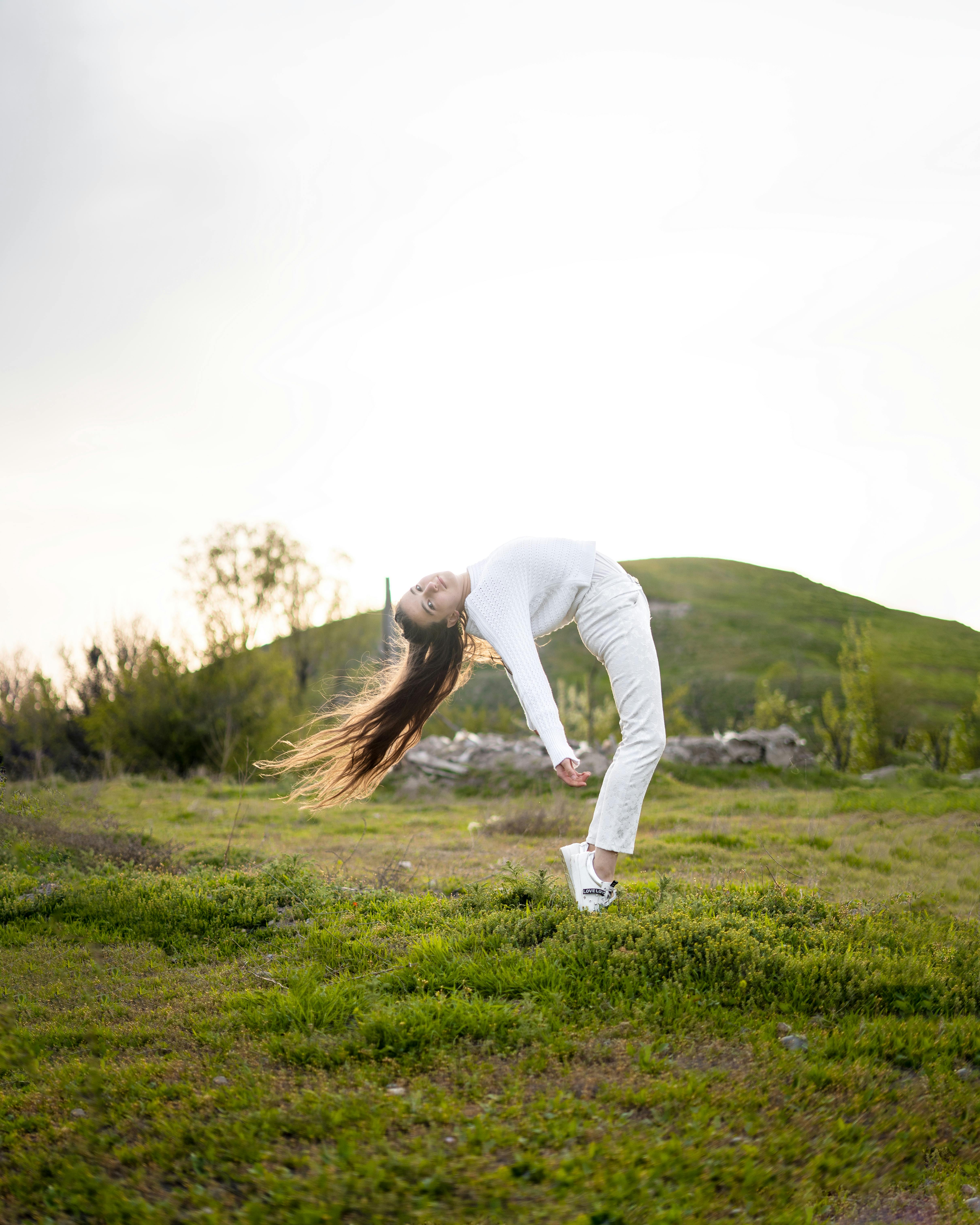 Women Posing on a Grass Field Under White Clouds · Free Stock Photo