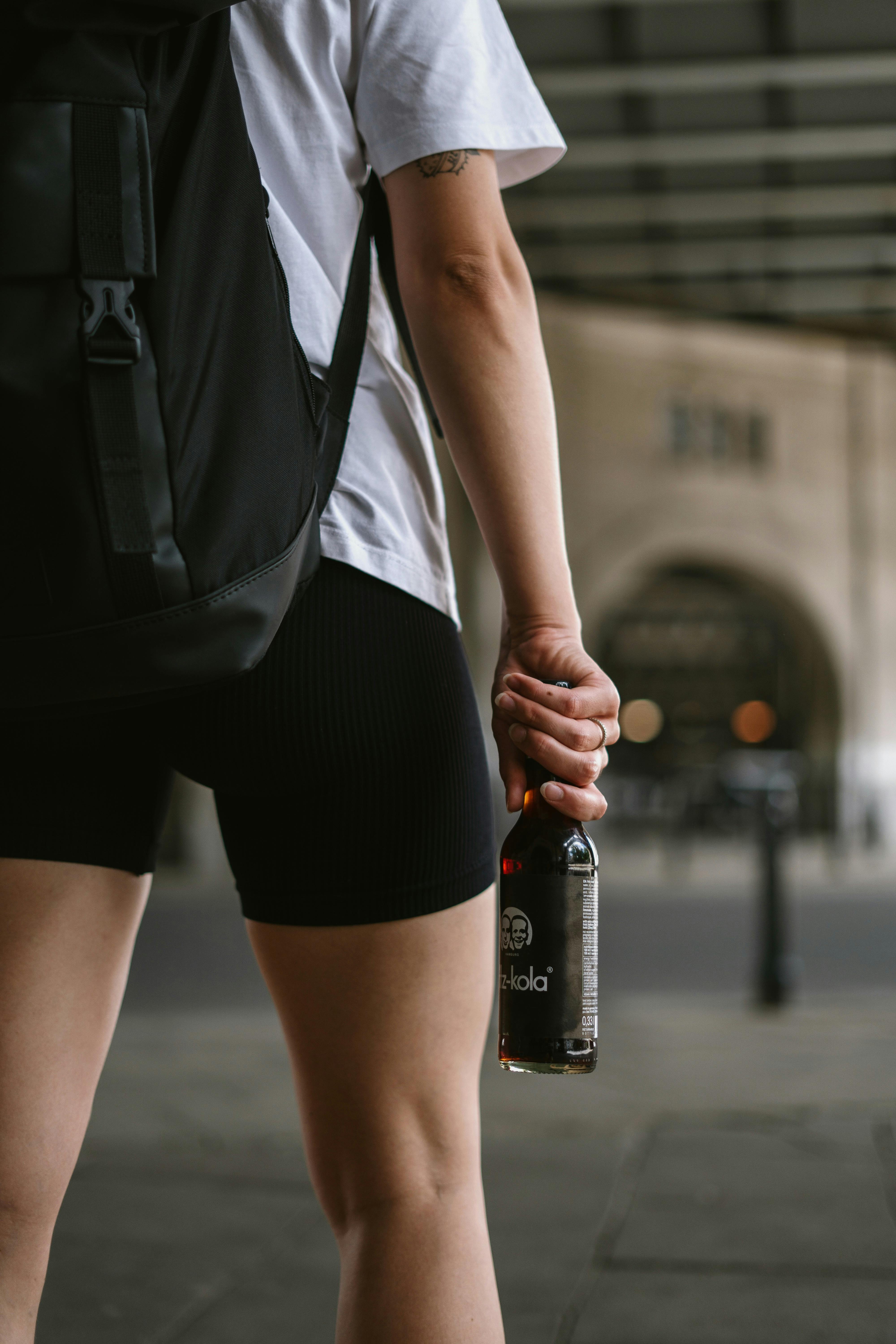 Person Wearing Backpack Holding Bottle of Fritz-kola · Free Stock Photo