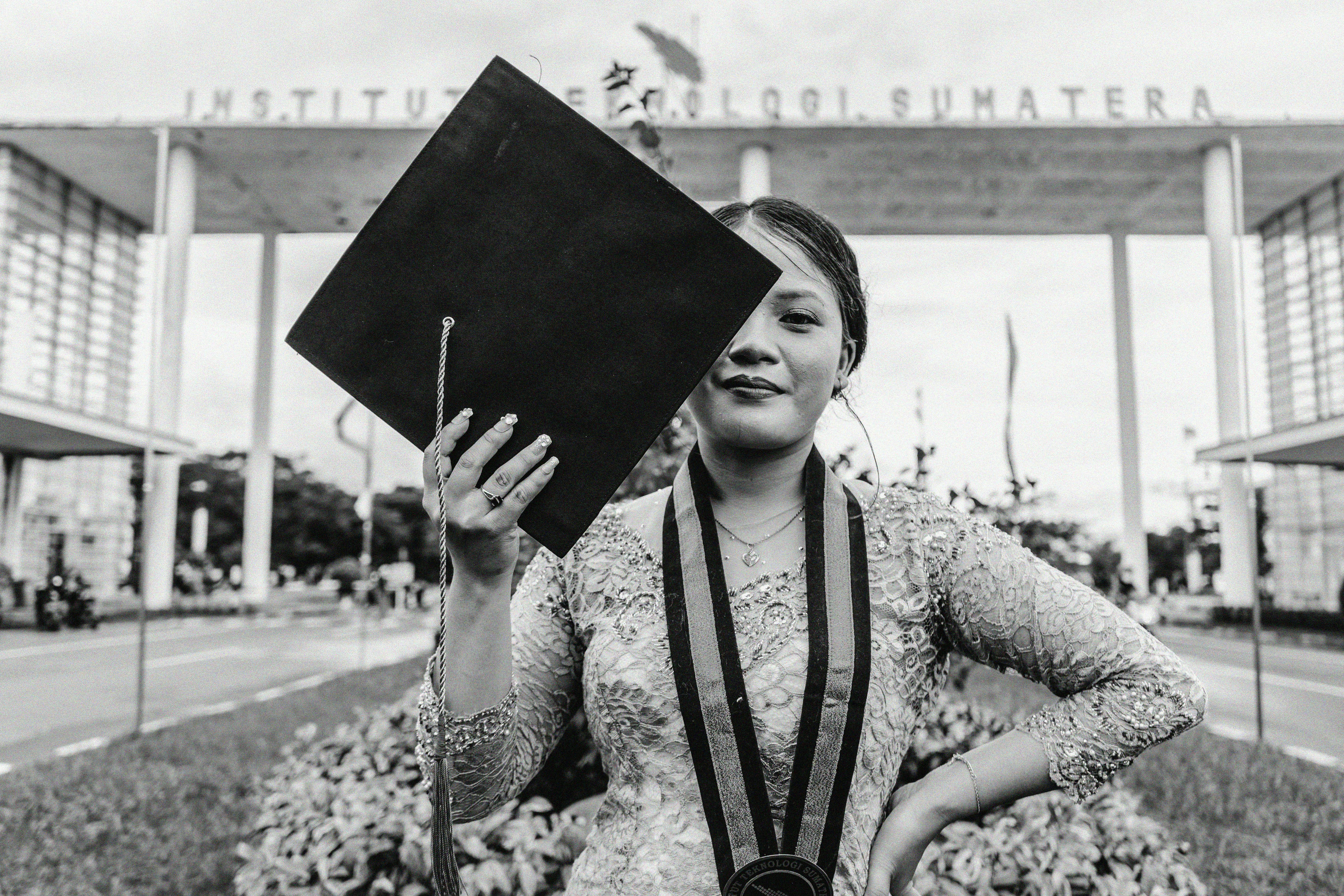 Grayscale Photo of Woman Holding a Graduation Hat · Free Stock Photo