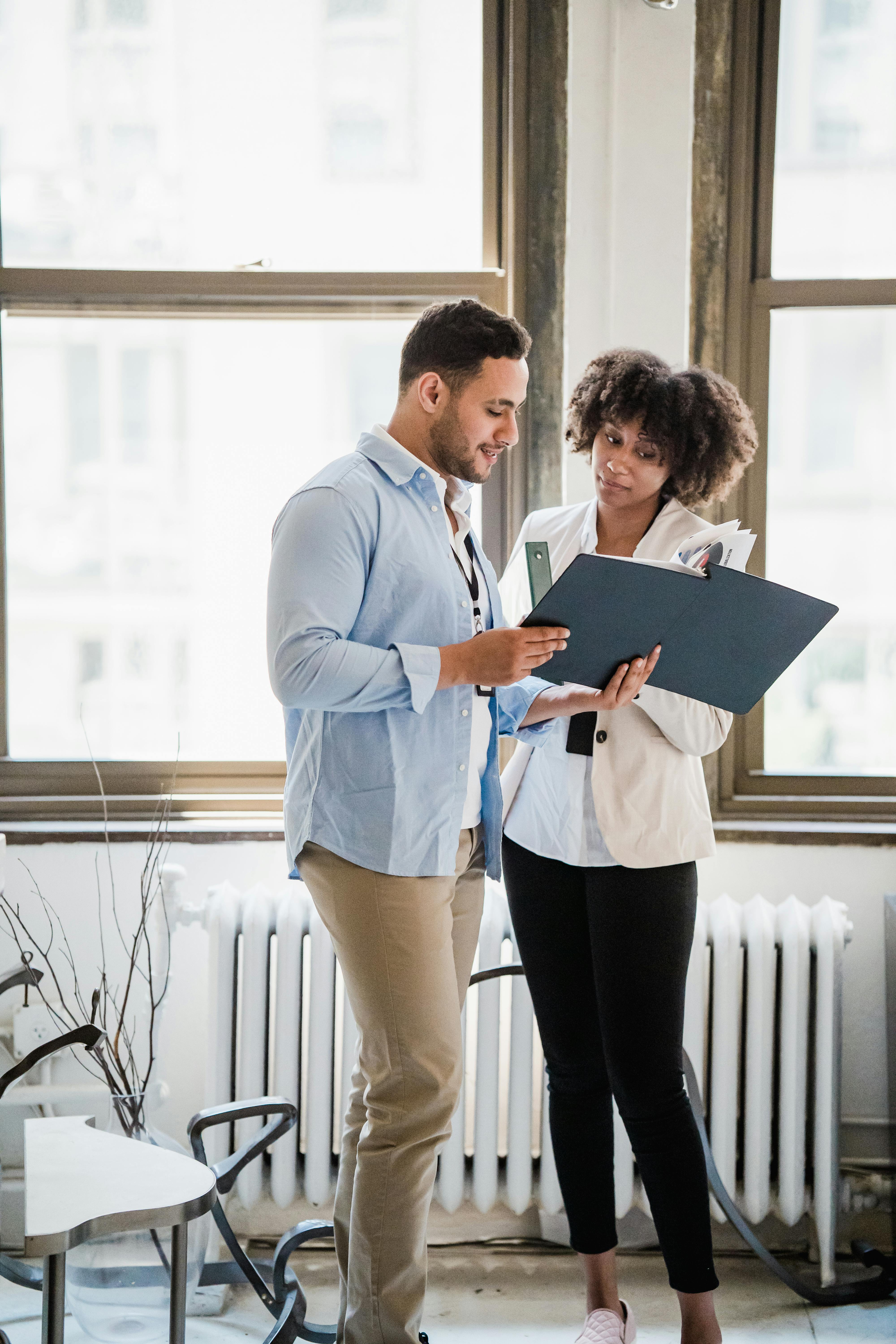 Woman and Man Looking at Documents · Free Stock Photo