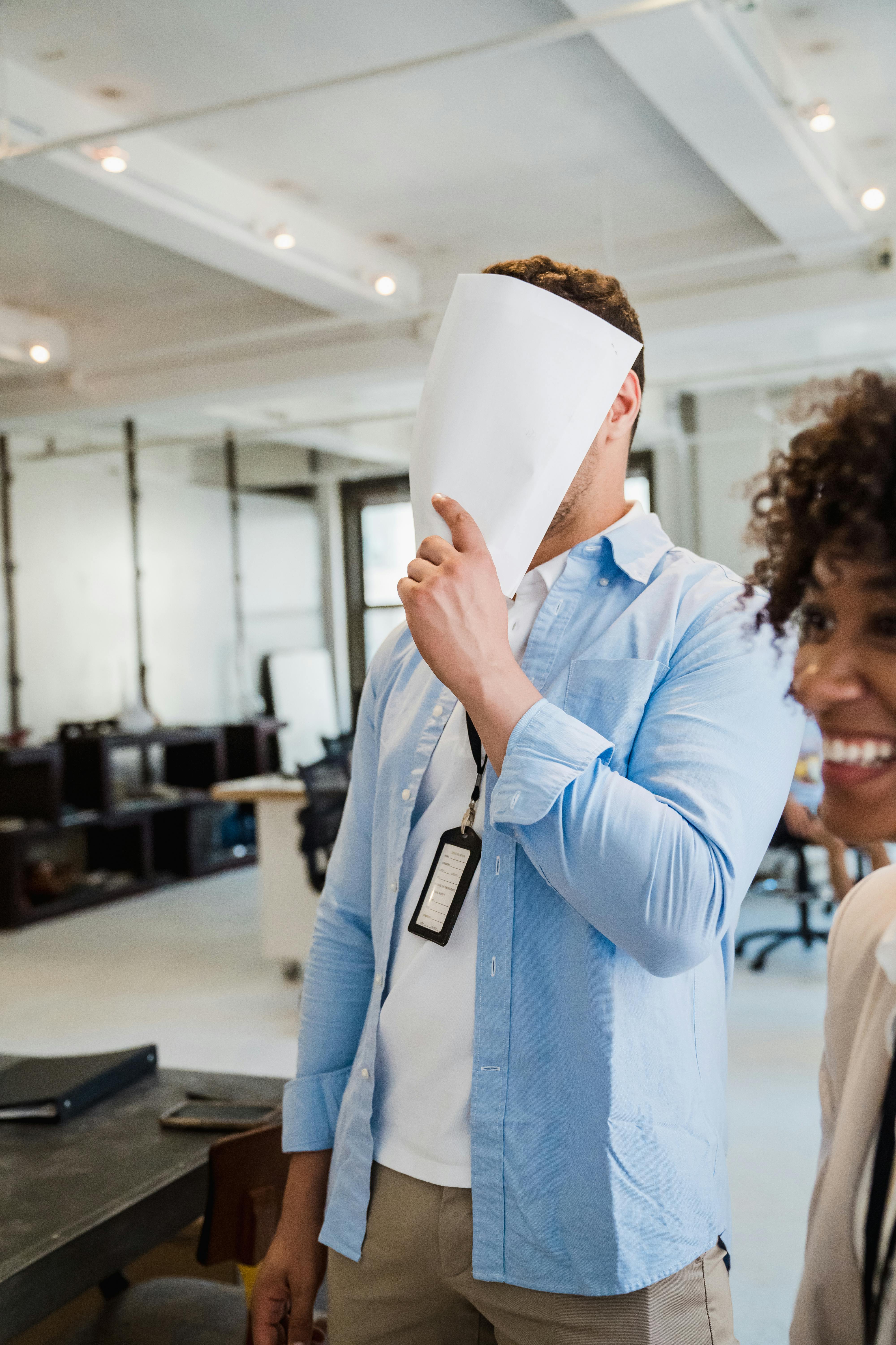 Man Covering Face with Sheet of Paper and Woman Smiling · Free Stock Photo