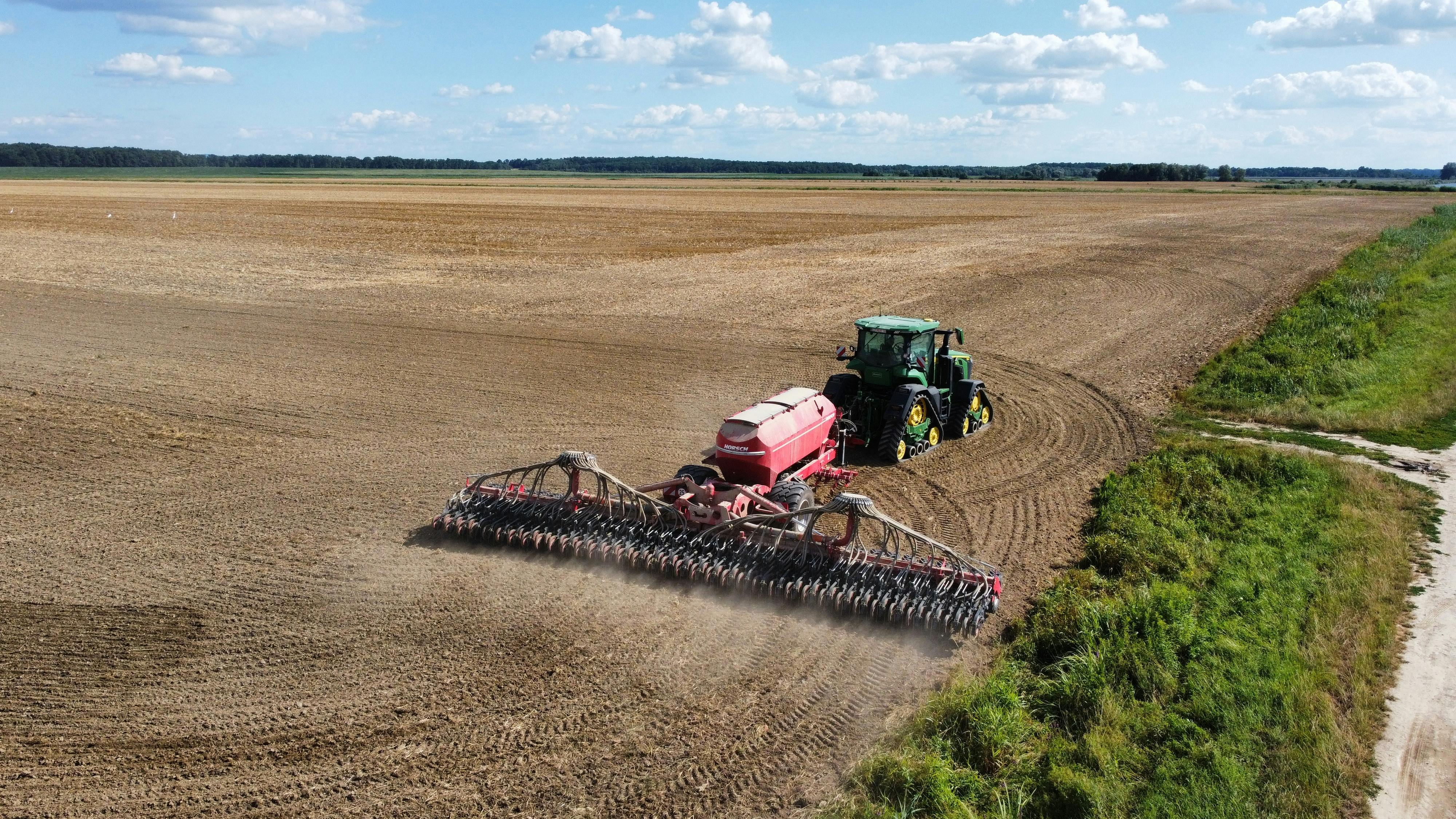 Heavy Machine Tractor Harvesting Crops on an Agricultural Farmland ...