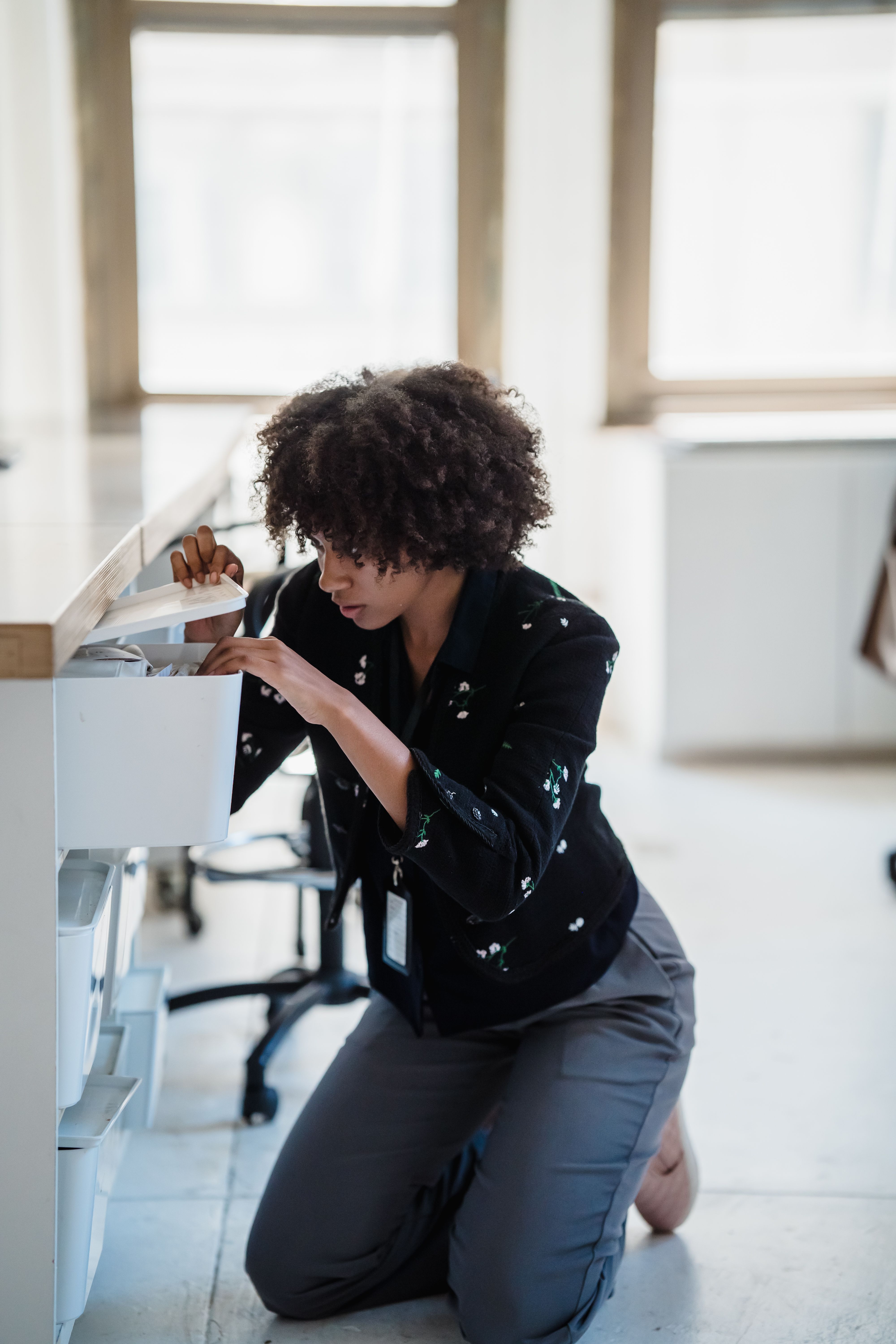 Woman Crouching in Office · Free Stock Photo