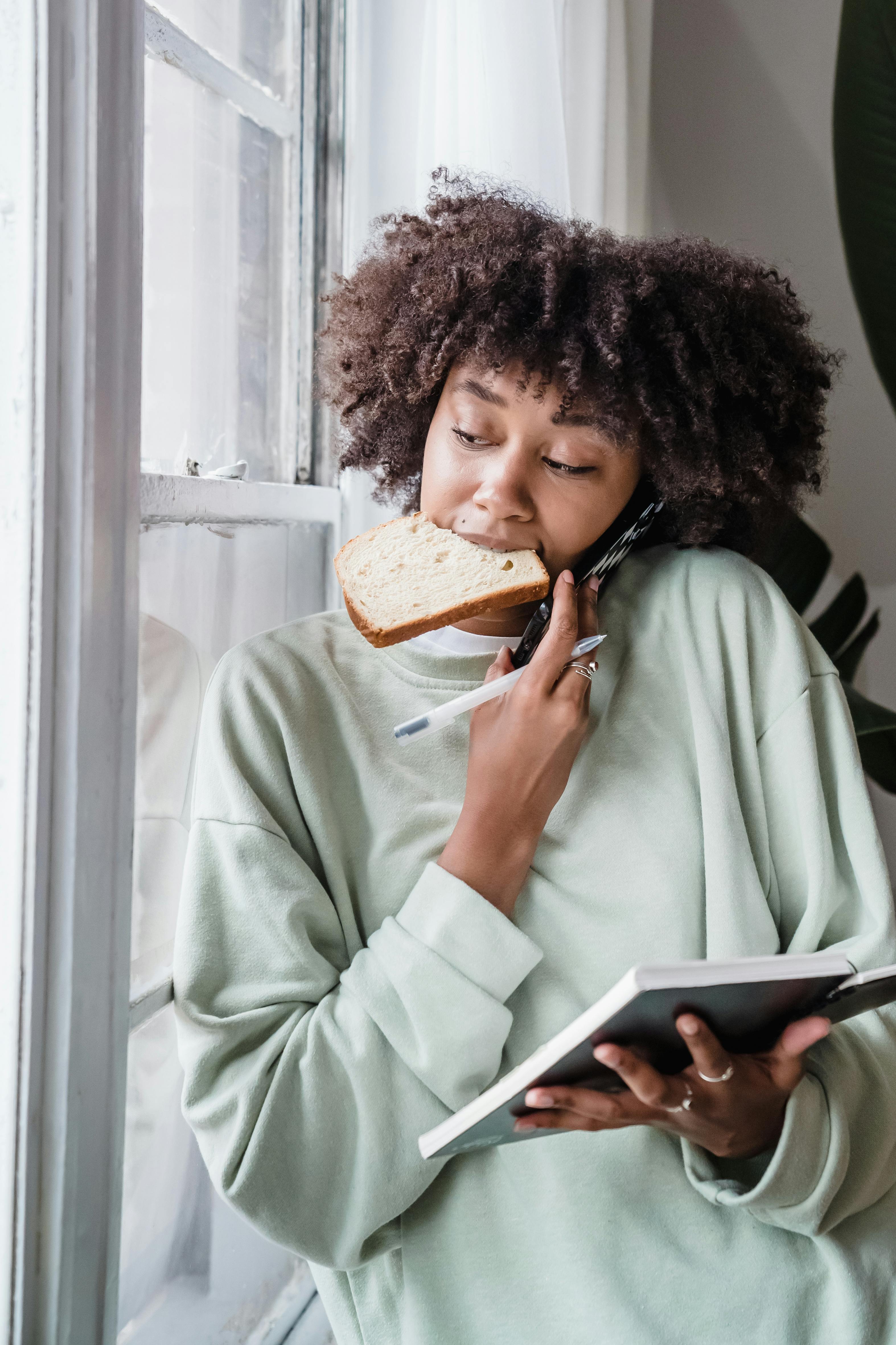 A Woman Eating by a Window · Free Stock Photo